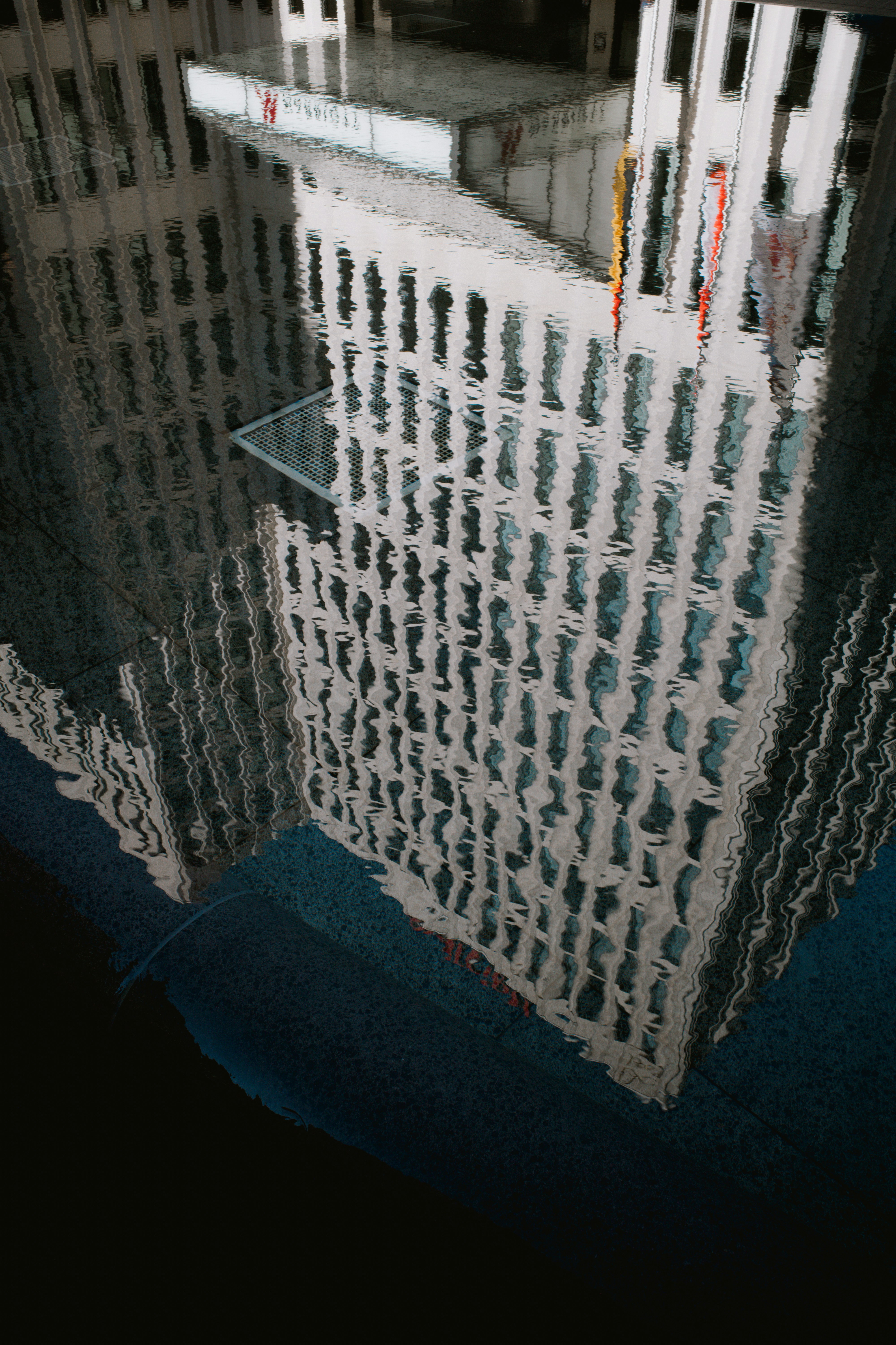 Reflection in an Urban Canopy: Looming Facade on Still Water