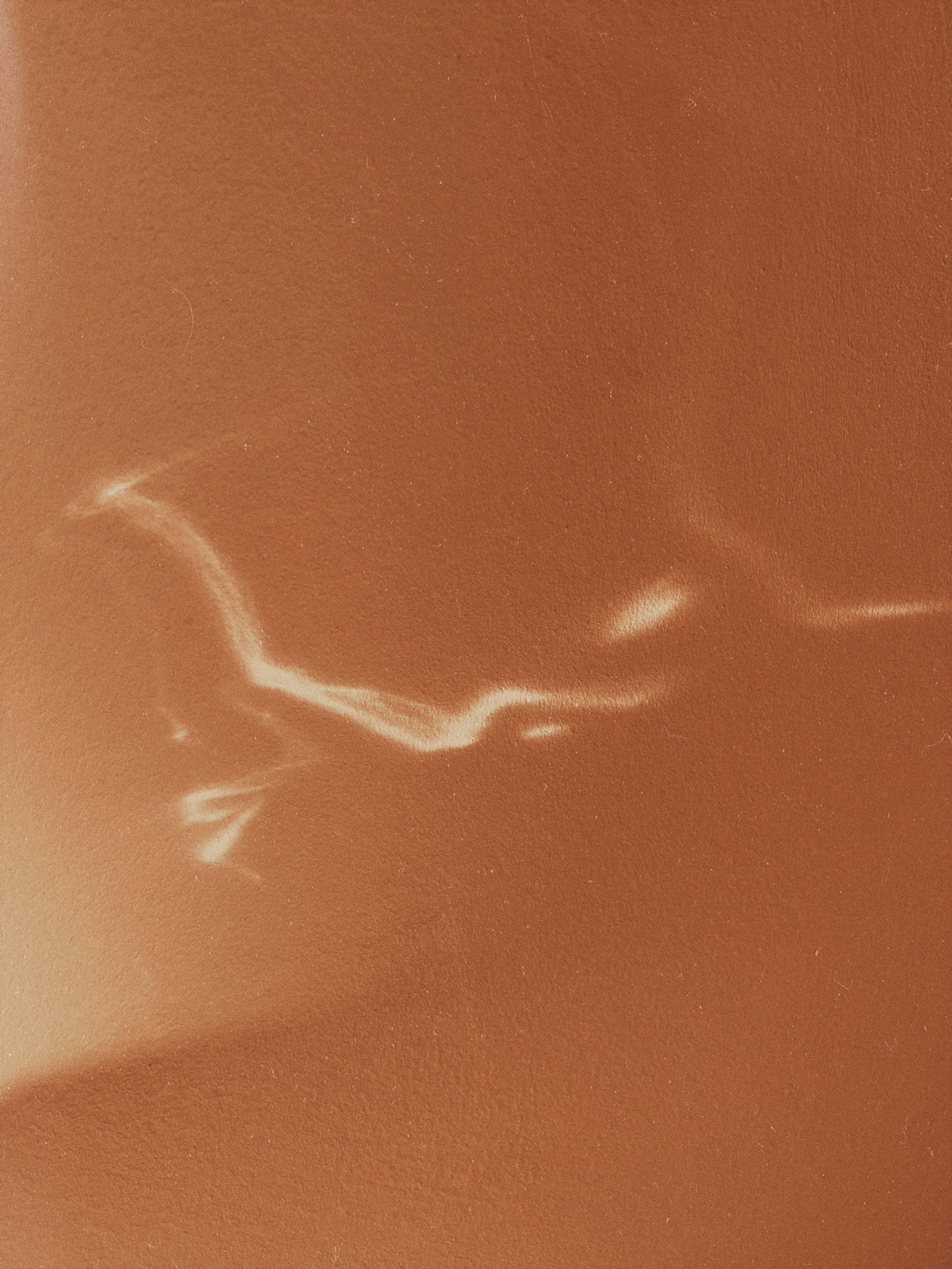 Cracked Surface Glow: A Silhouette of Light on Warm Leather