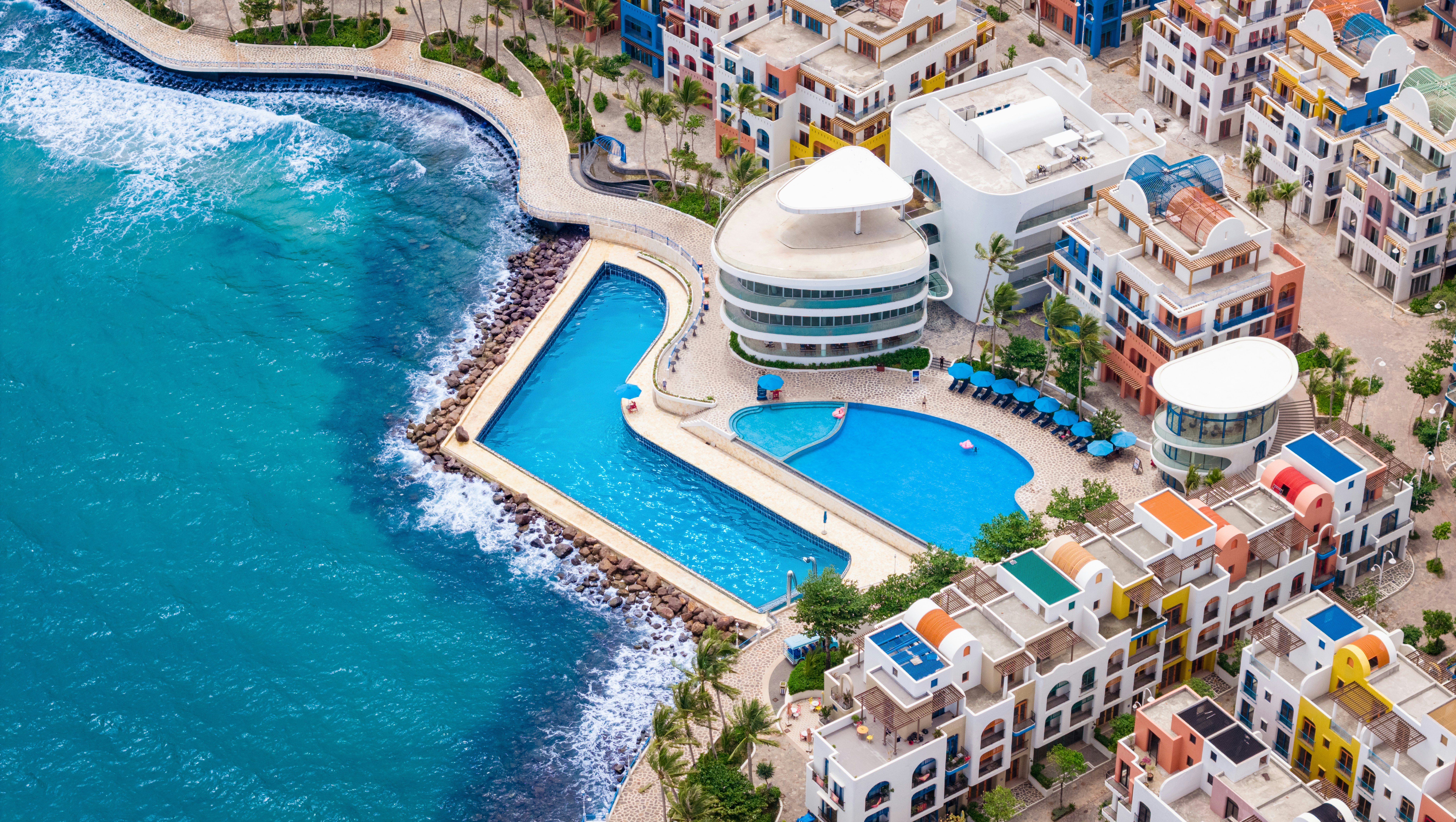 Aerial Oasis: Colorful Marina Village and Serpentine Pool by the Sea