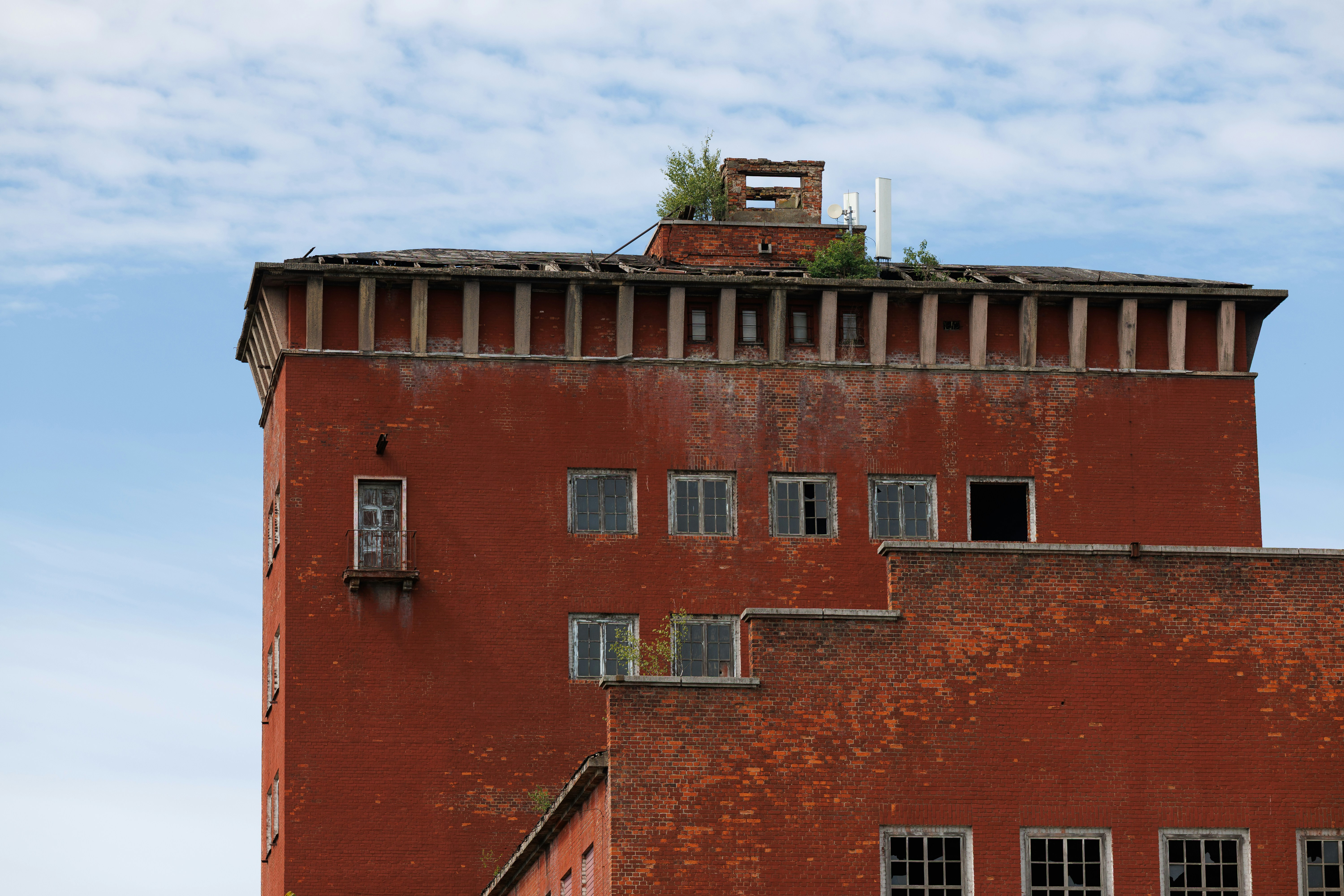 Red Brick Corner: A Stacked Industrial Facade under a Narrow Sky