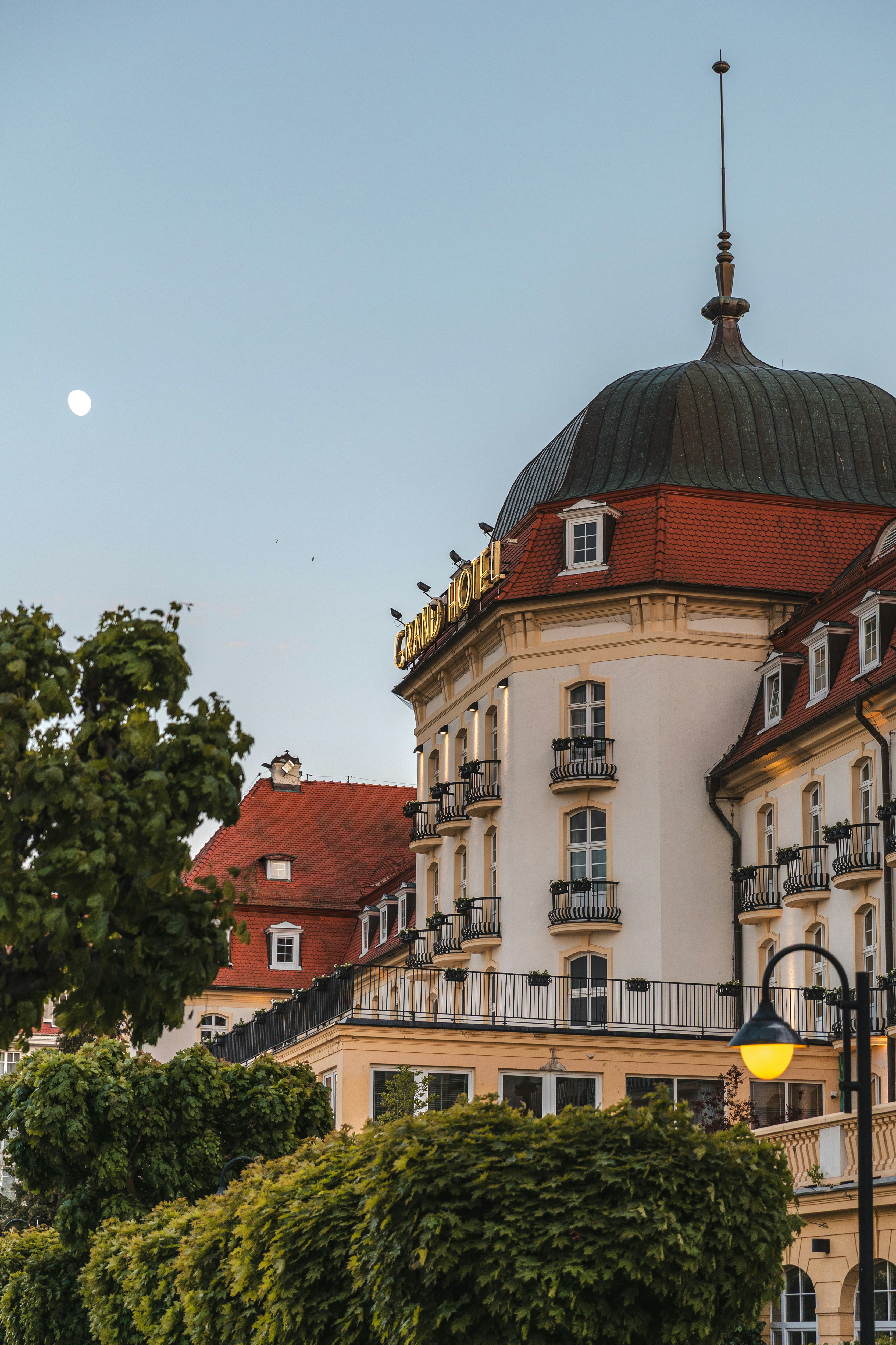 Facade of a Grand Hotel at Dusk with Crescent Moon
