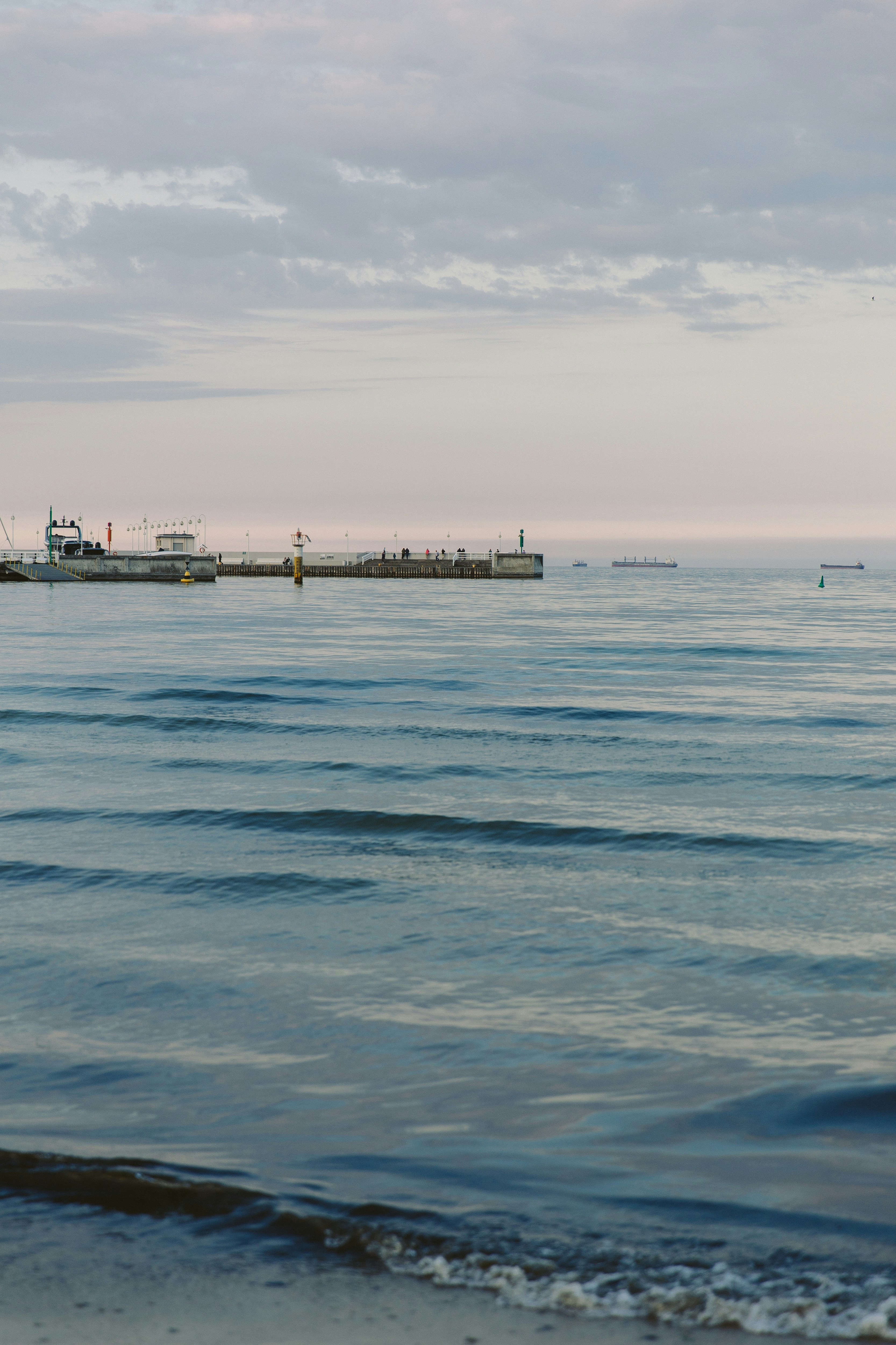 Harbor Horizon: Boats and Breakwater beneath a Calm Sky
