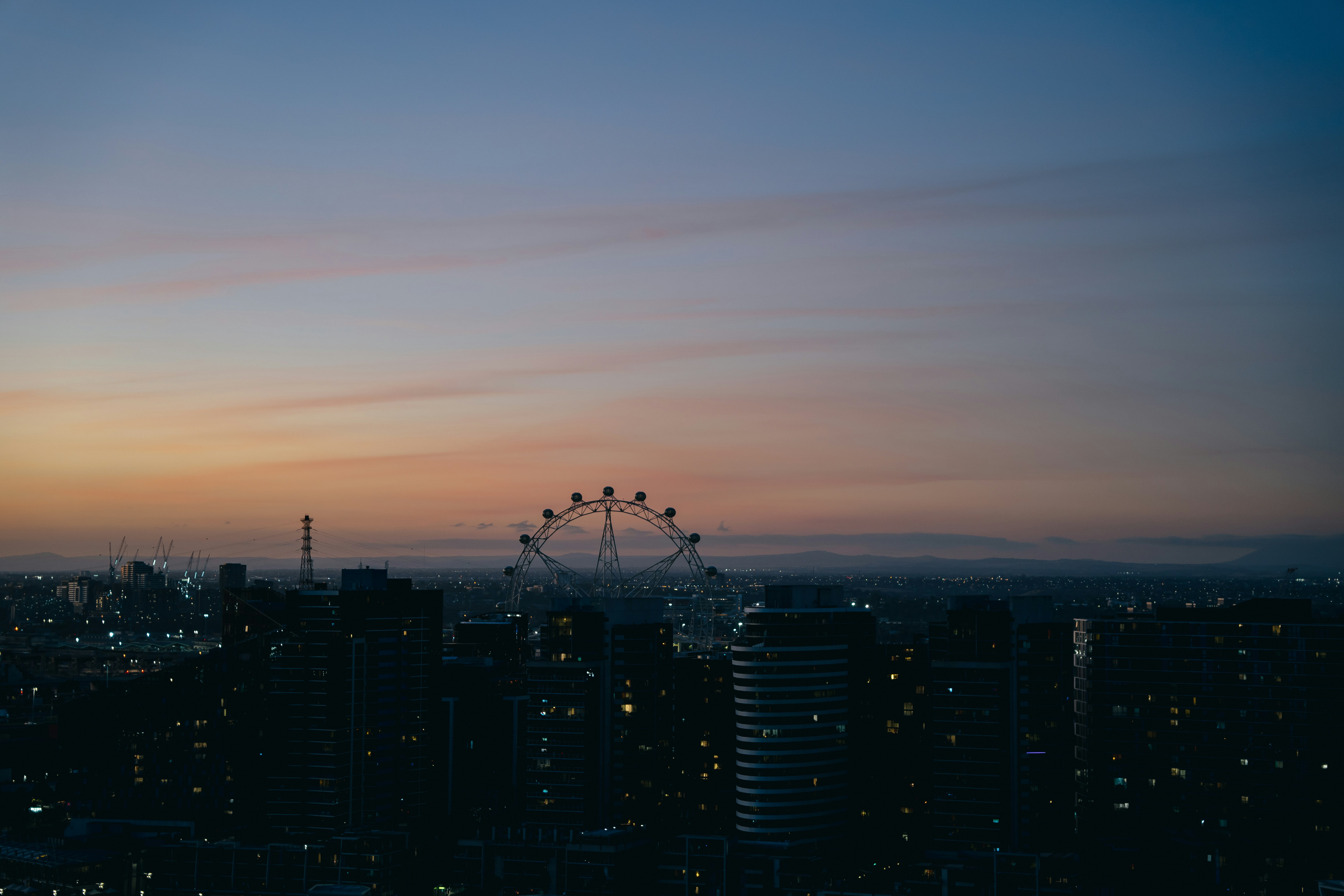 Dusk over the City: Ferris Wheel Silhouette at Sunset