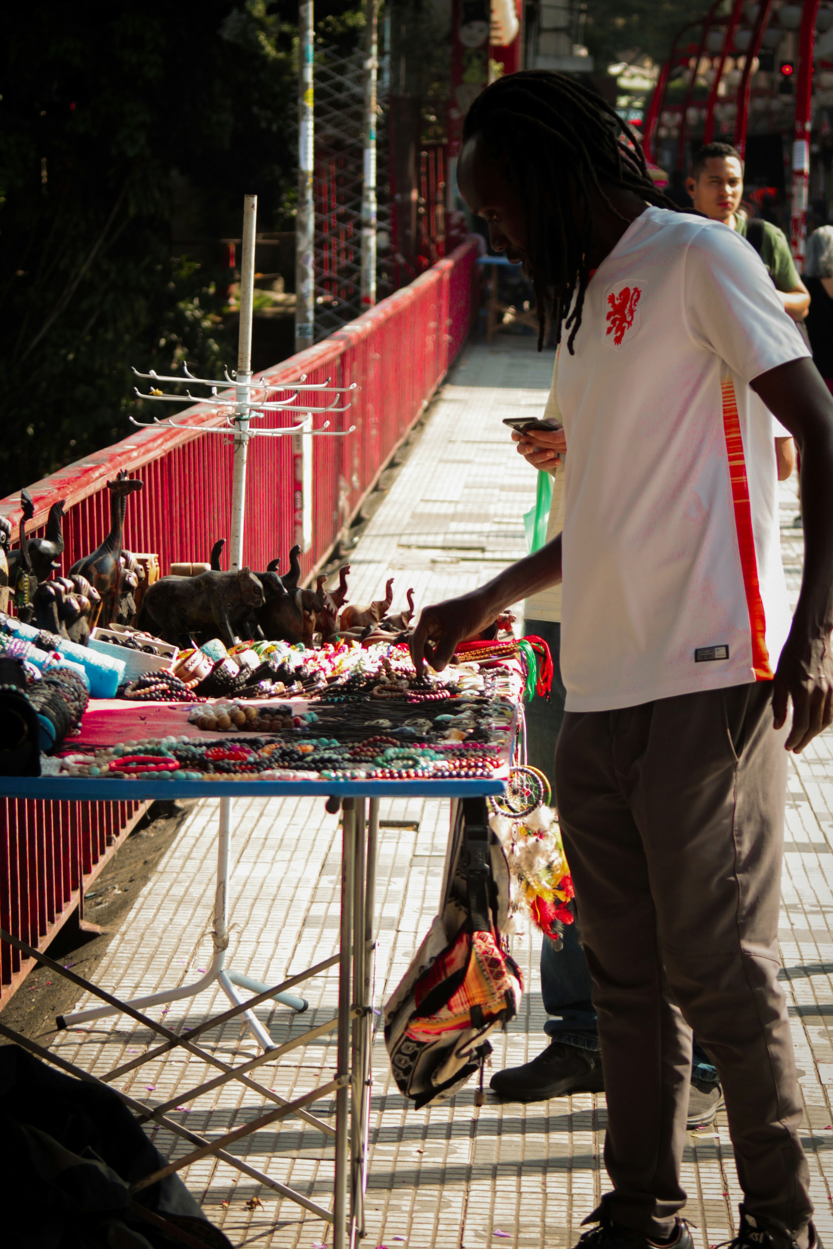 The Bead Trader: Focused Gaze at a Street-side Jewelry Stall