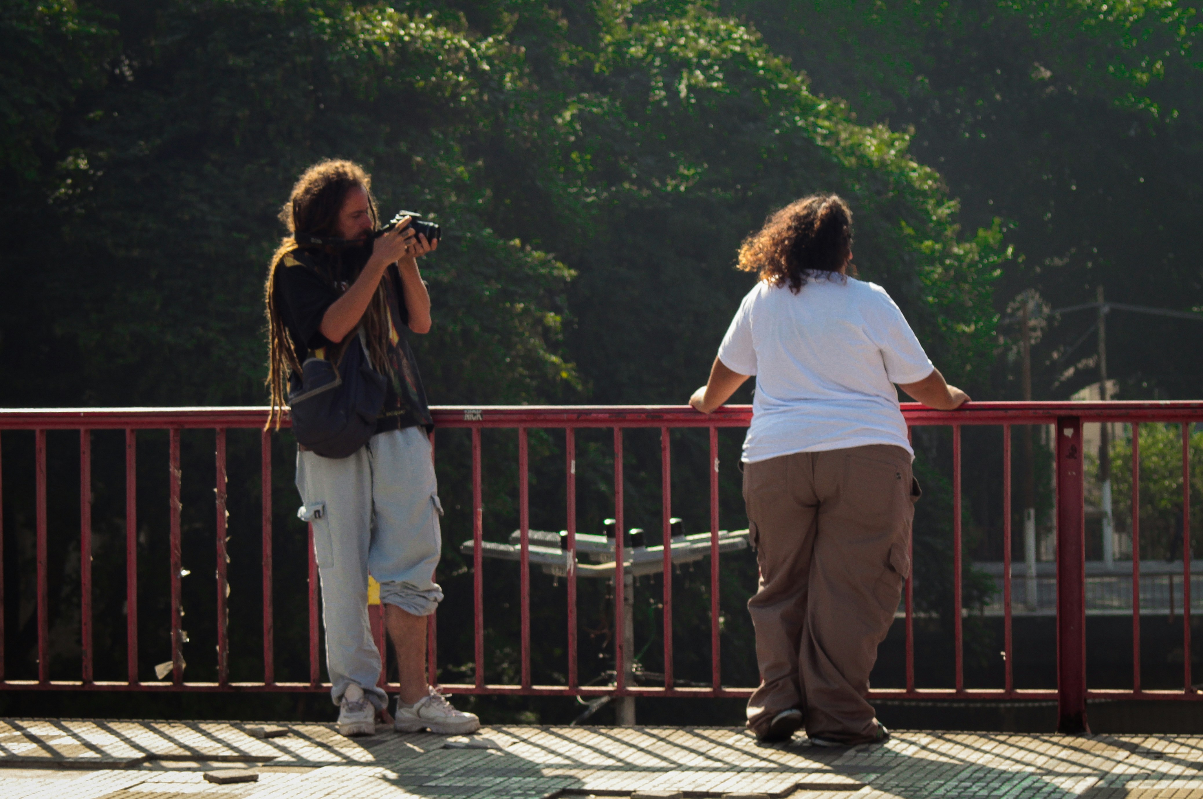 Photographers on a sunlit bridge: capturing moments from behind