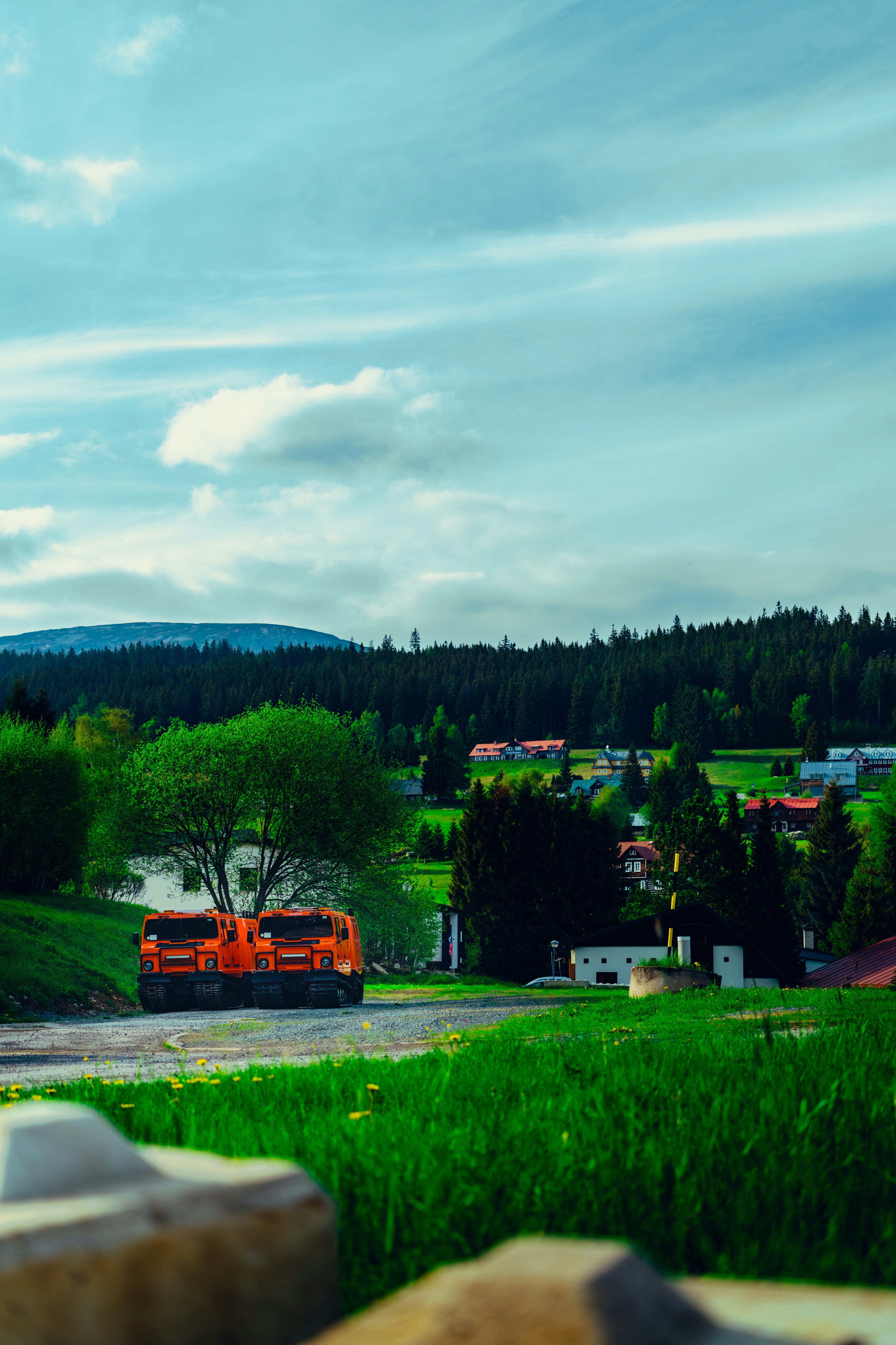 Emerald Fields and Orange Haulers at the Edge of Town