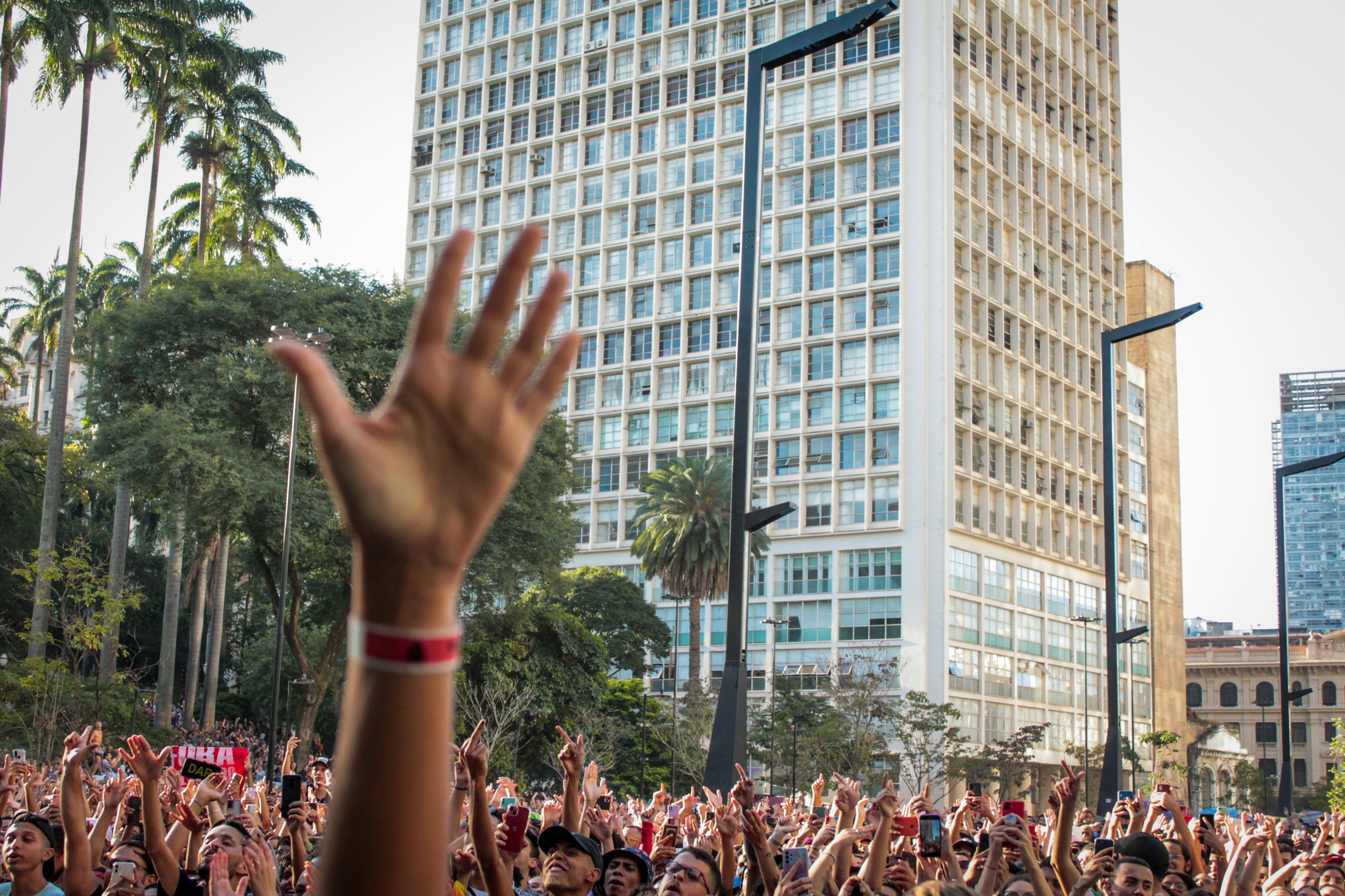 Raise of Hands: City Crowd at Dusk
