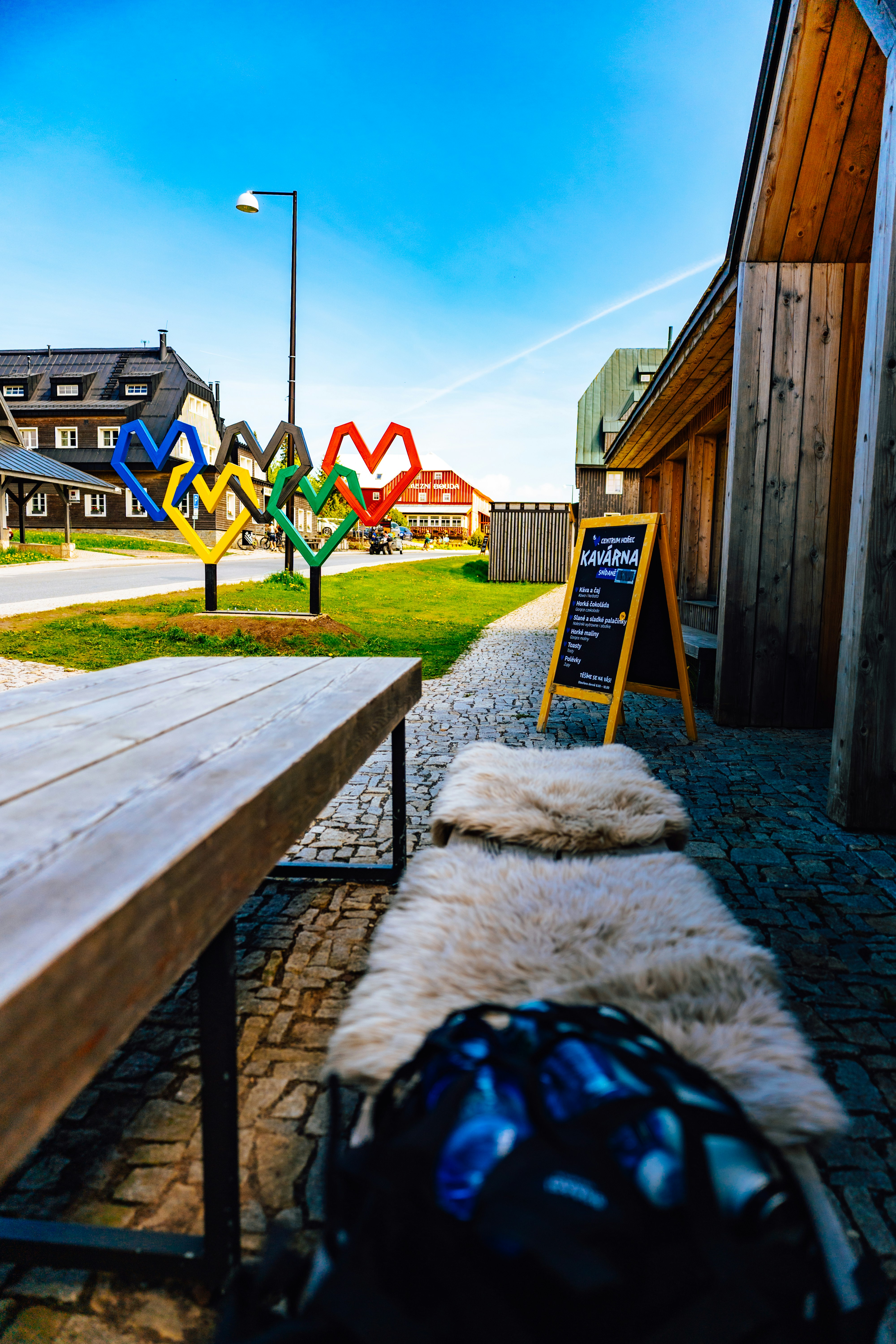 Geometric Heart of the Village: Colorful Signposts by the Cafe