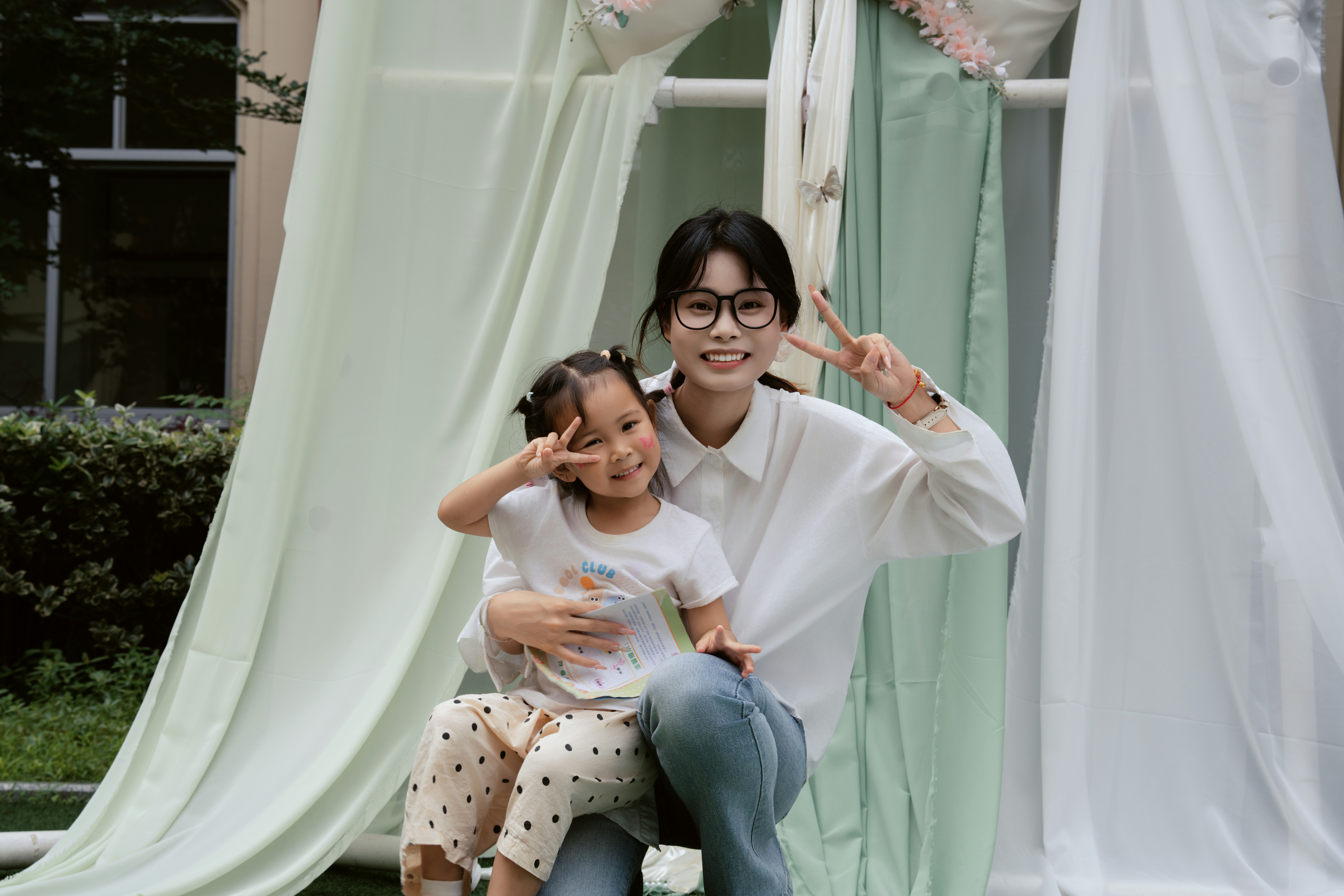Sisterly Smile: Quiet Joy Between Portrait and Playground Drapes