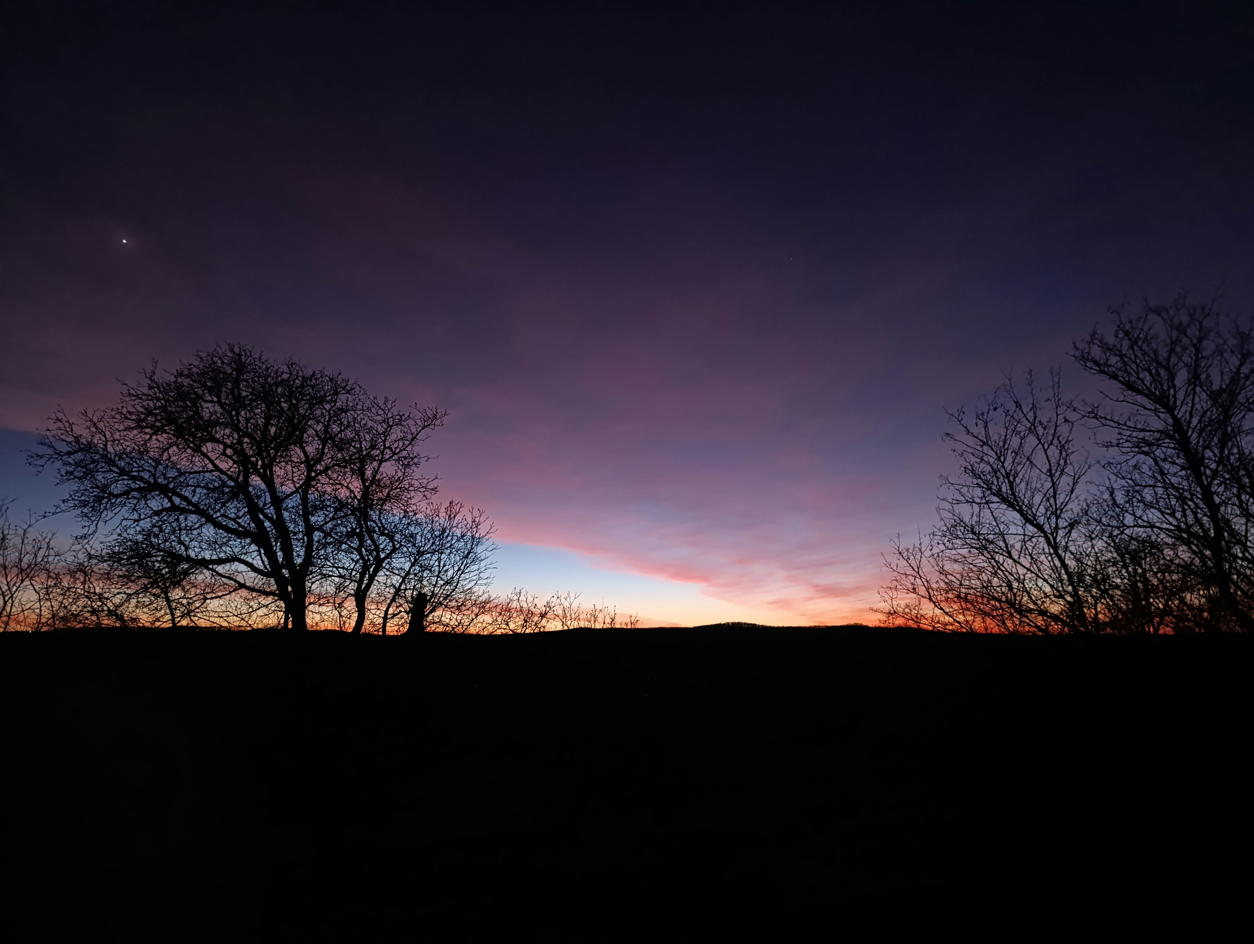 Silhouetted Horizon at Dusk: A Quiet Landscape as Night Falls