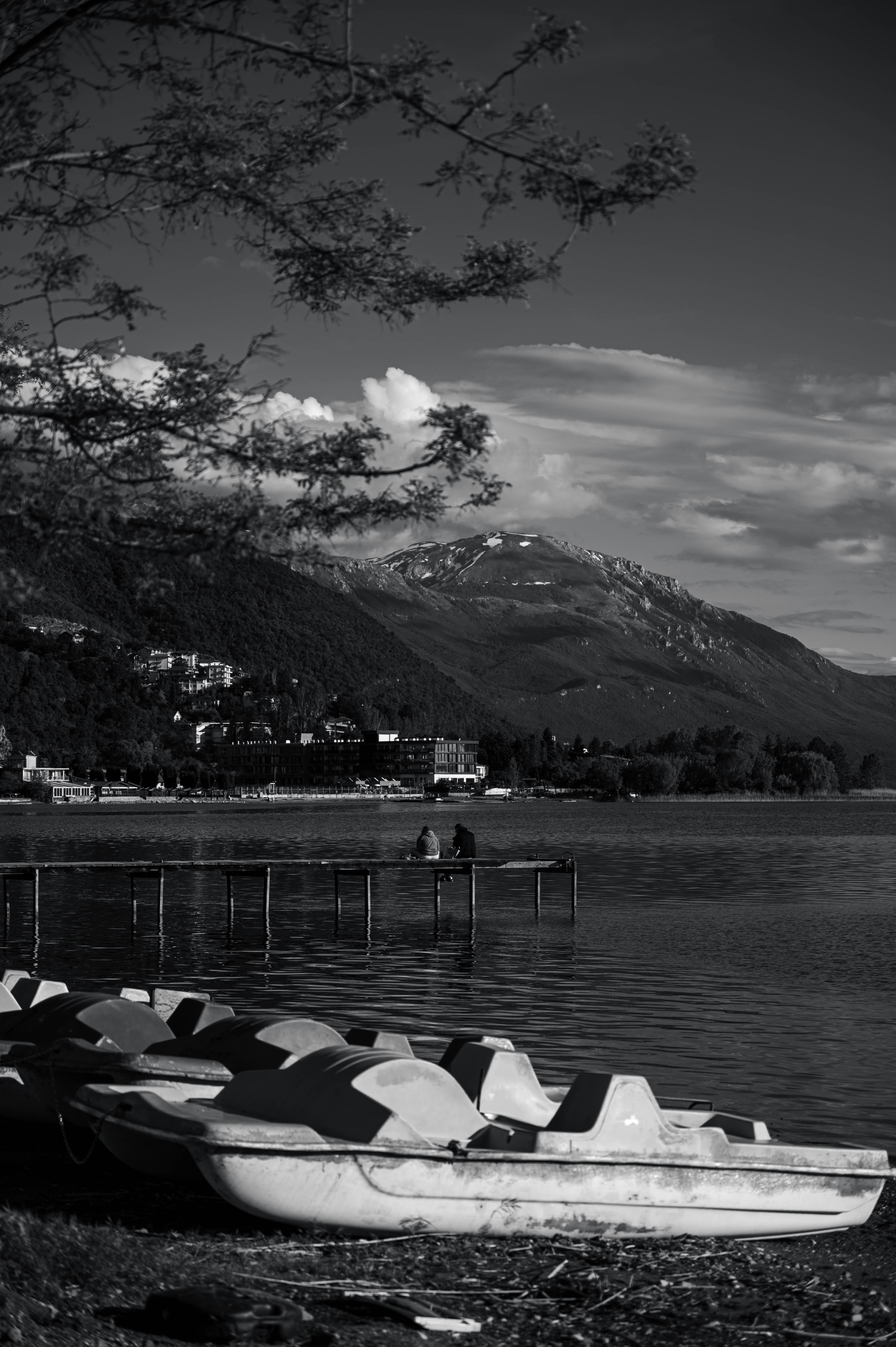 Evening on the Lake: Boats Rest at the Quiet Shore with Snow-capped Peak
