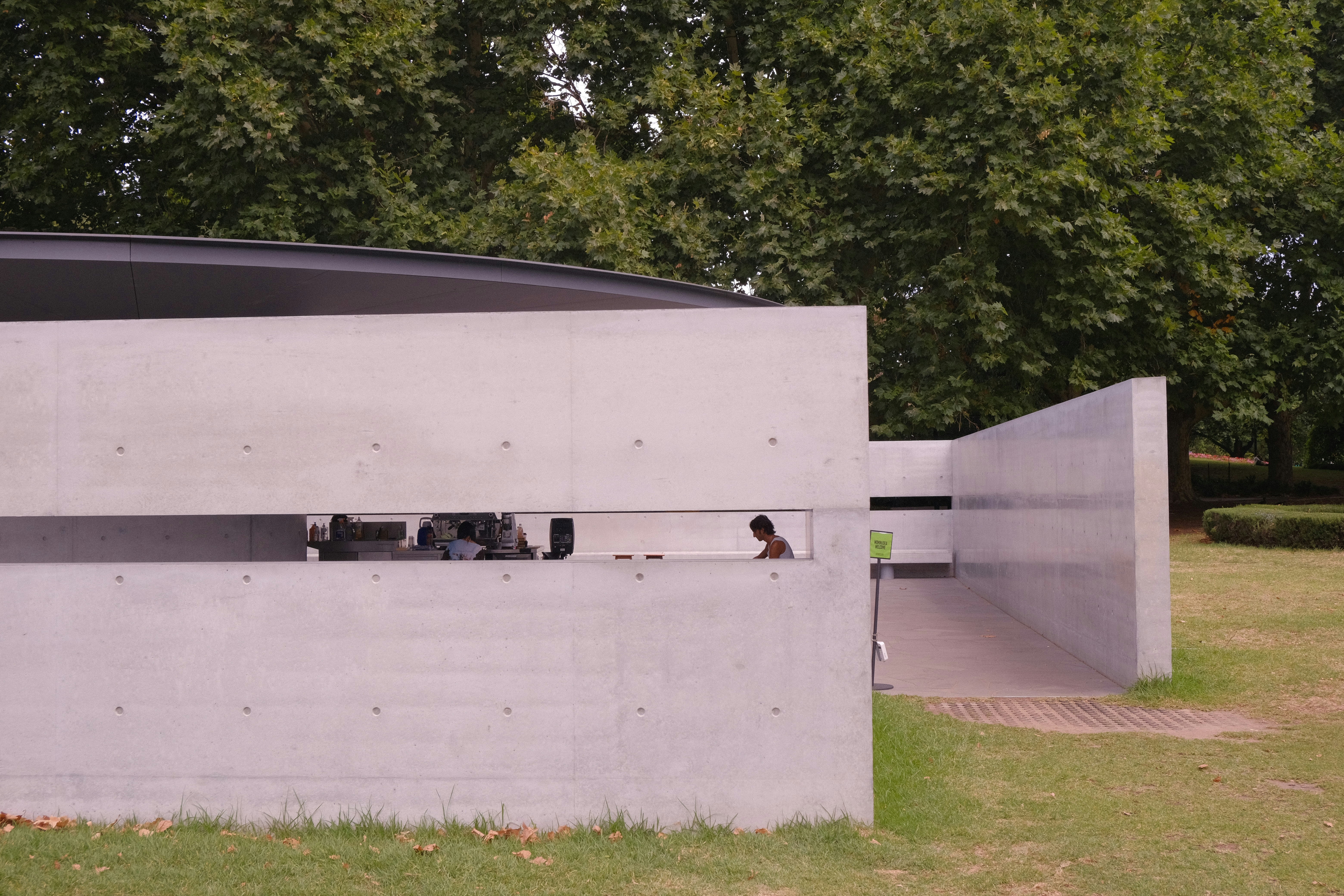 Concrete Pavilion Cutout: Minimalist Corridor with Human Interest
