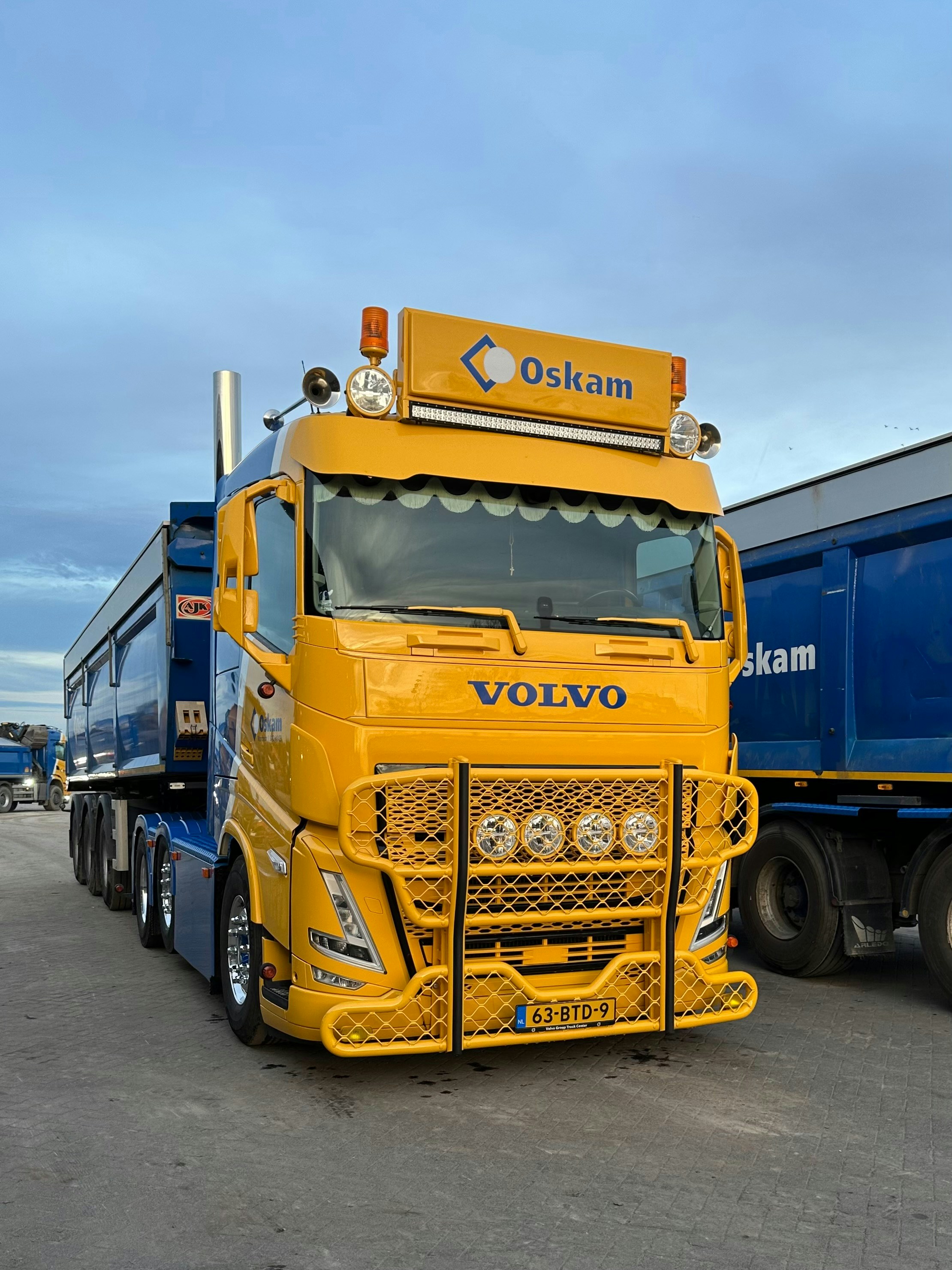Golden Colossus: A Volvo Hauler Guarding the Dock