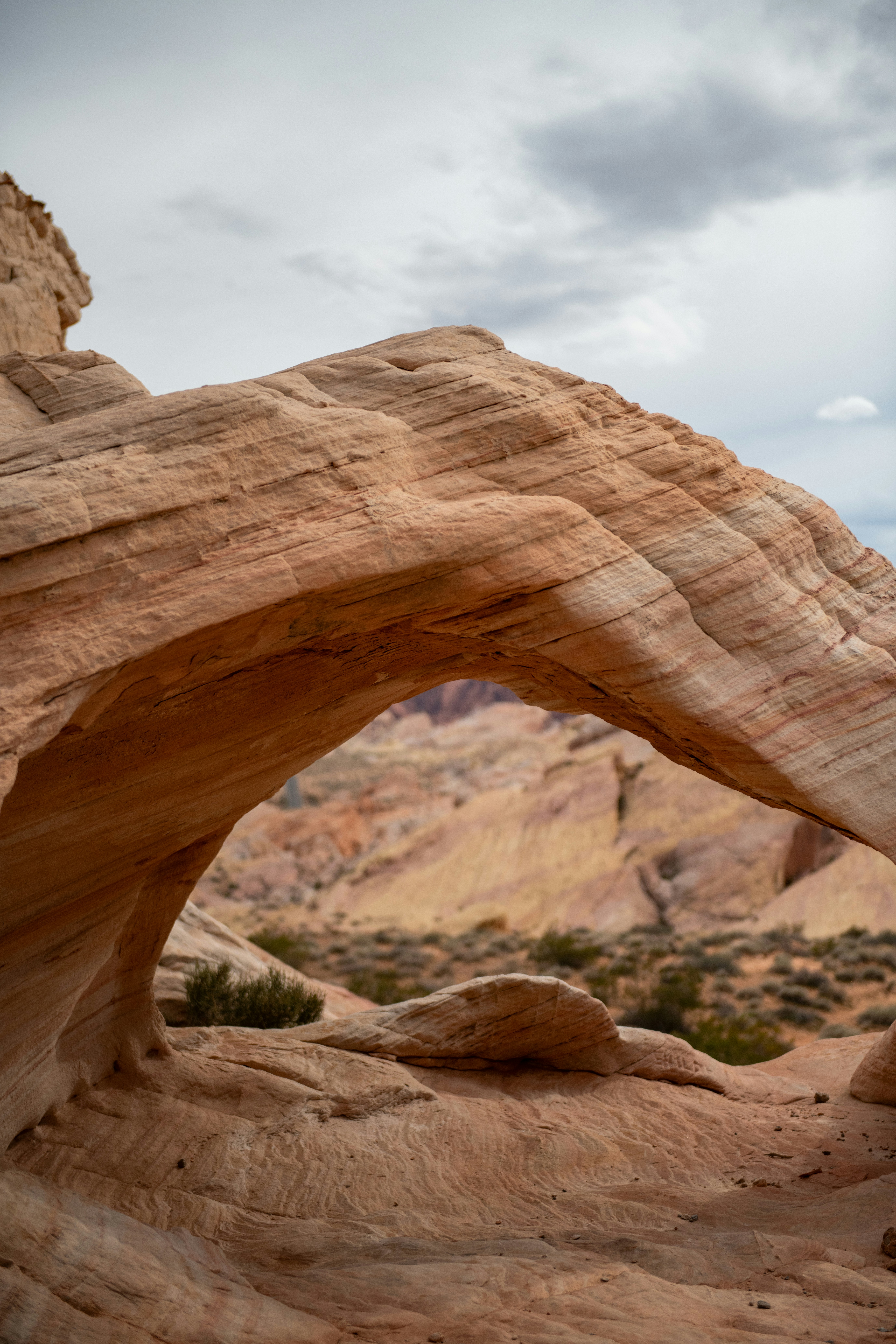 Stone Arch in Desert Light: A Natural Bridge Framed by Eroded Terrains