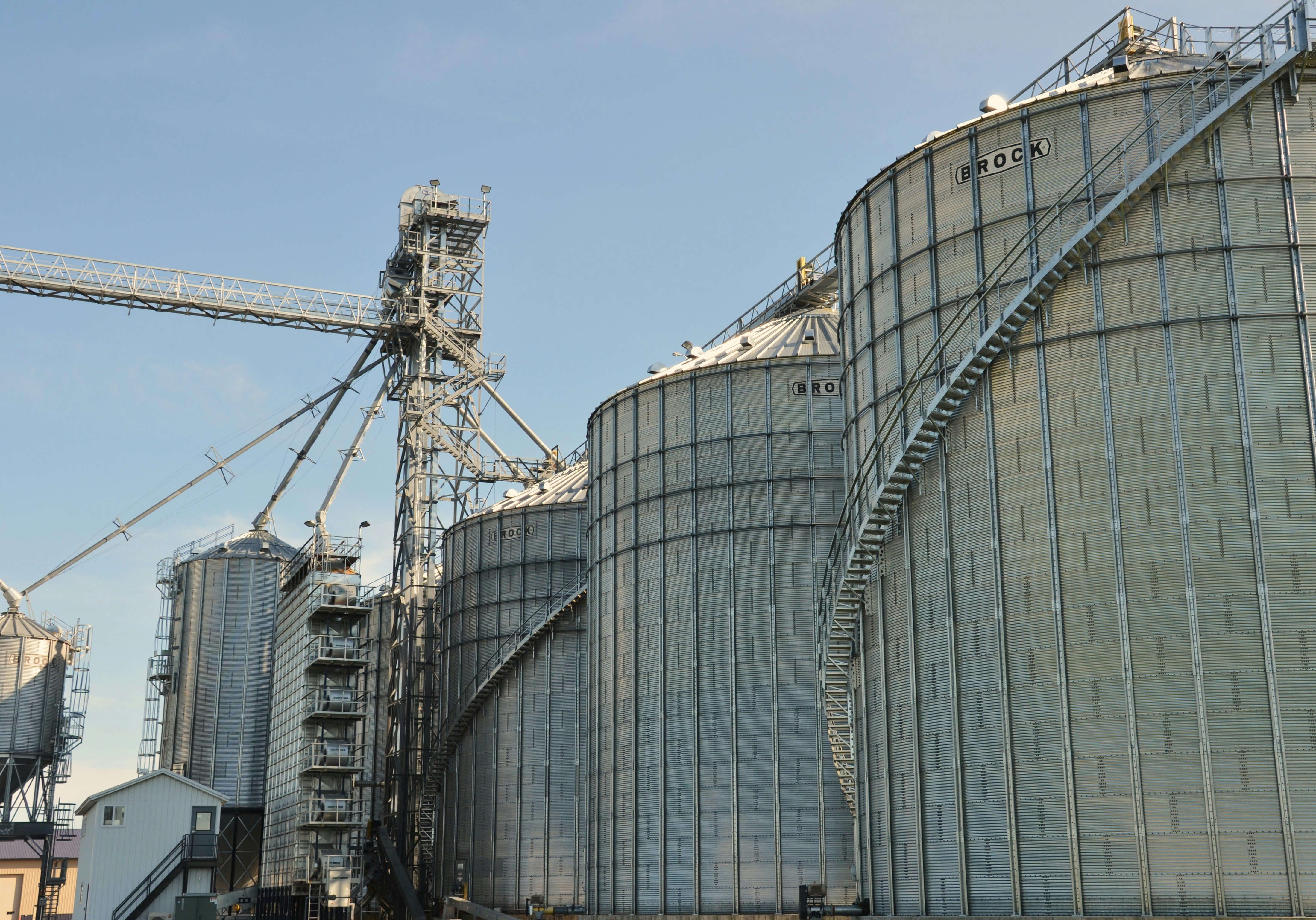 Grands silos à grains métalliques et complexe industriel sous un ciel ...