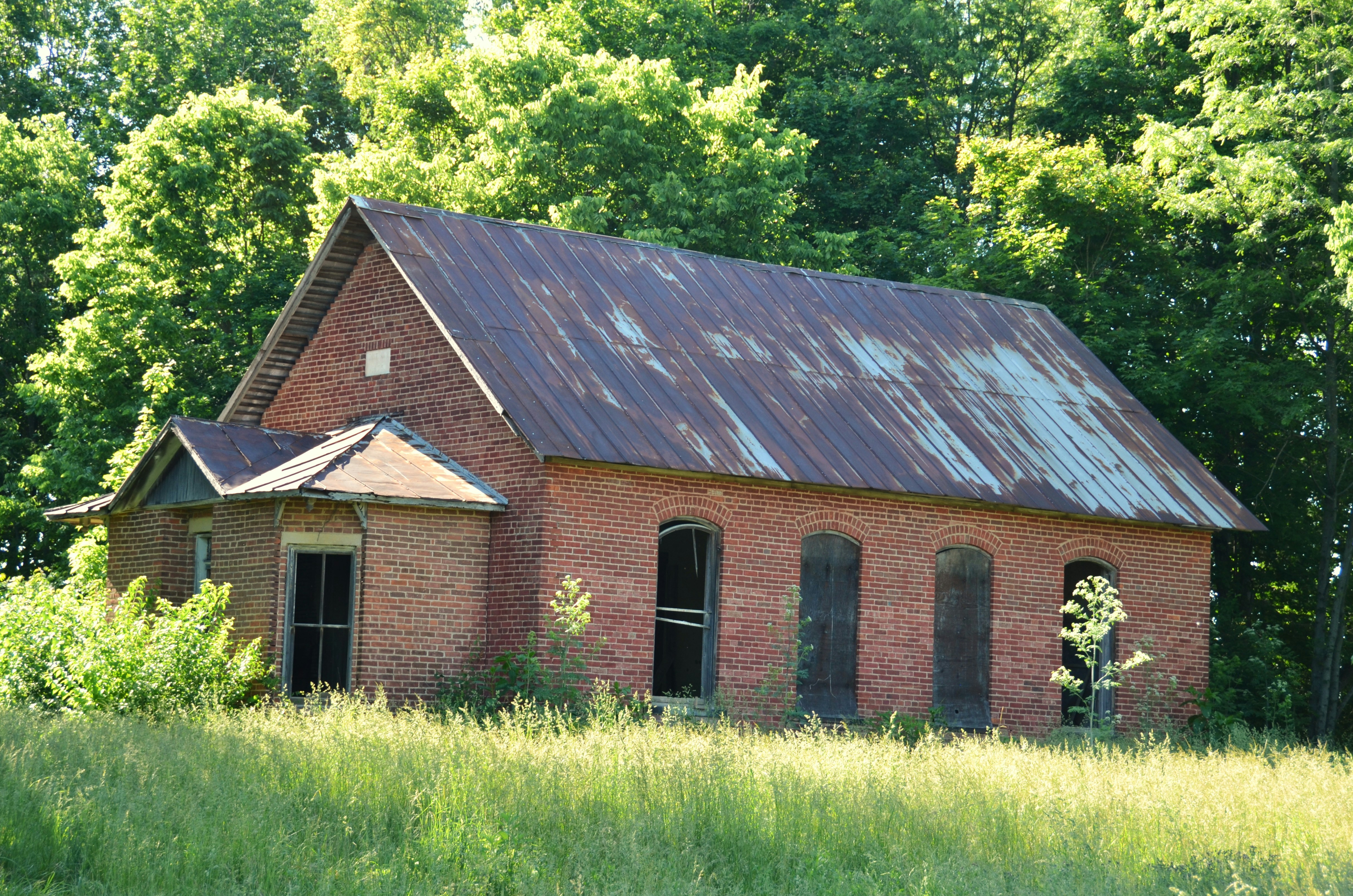 Rusty-roofed Brick Barn Housed by Sunlit Meadow