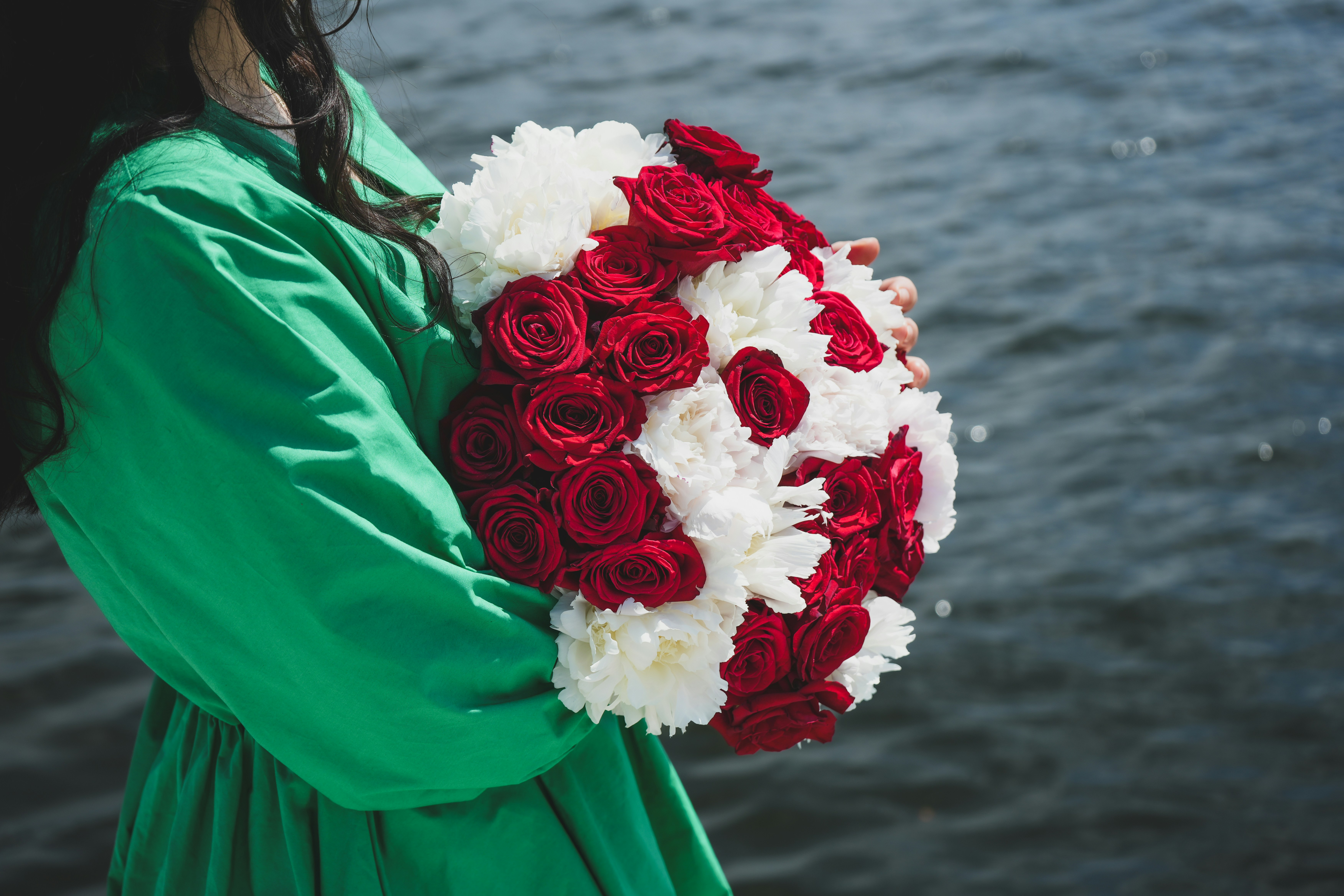 Bouquet of Red and White Roses in Emerald Attire by the Waterfront