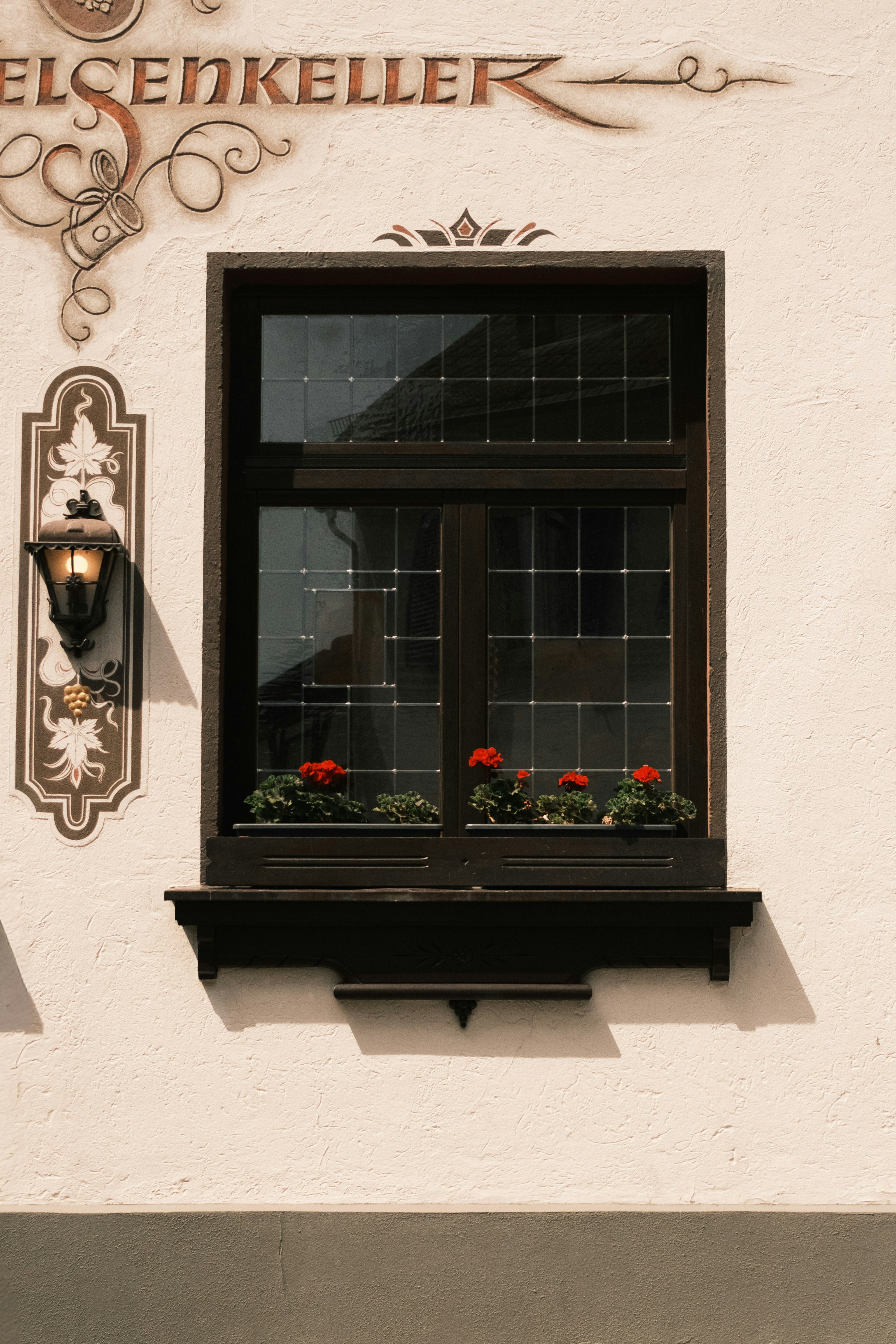 Cozy Window Box in Painted Facade with Decorative Sconce