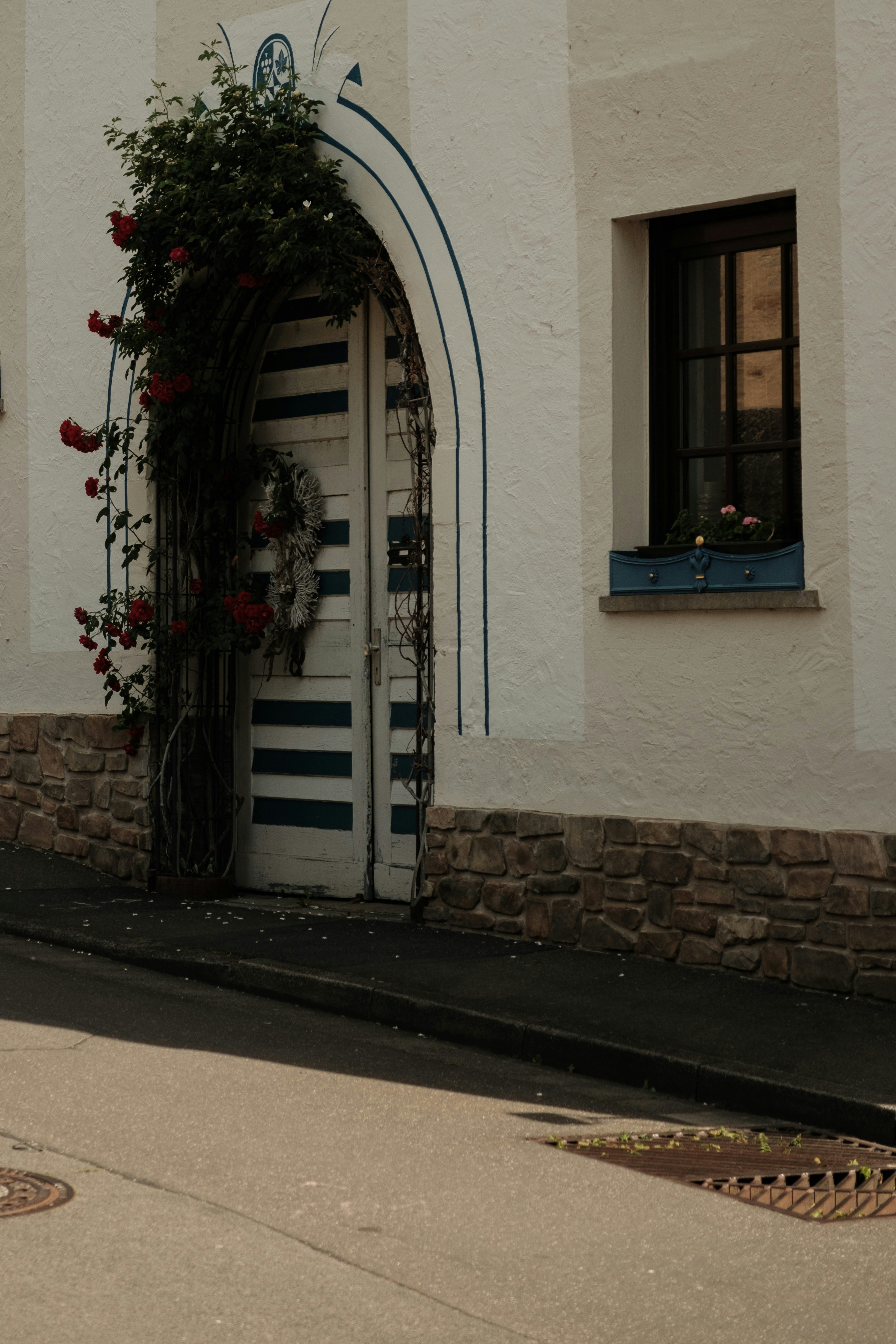 Arched Doorway Veiled by Roses on a Quiet Street