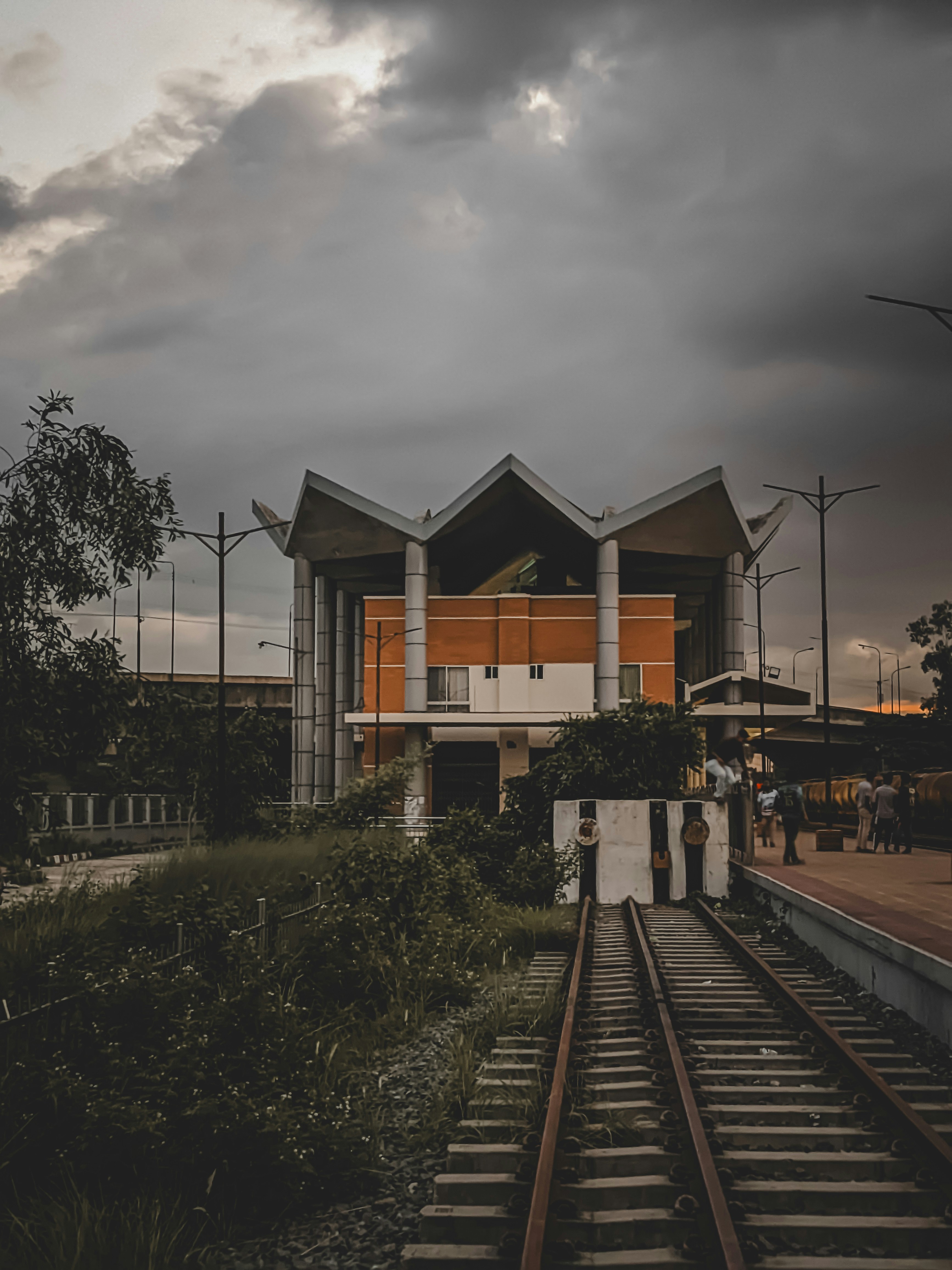 Orange Facade Beneath Stormy Skies at a Railroad Plaza