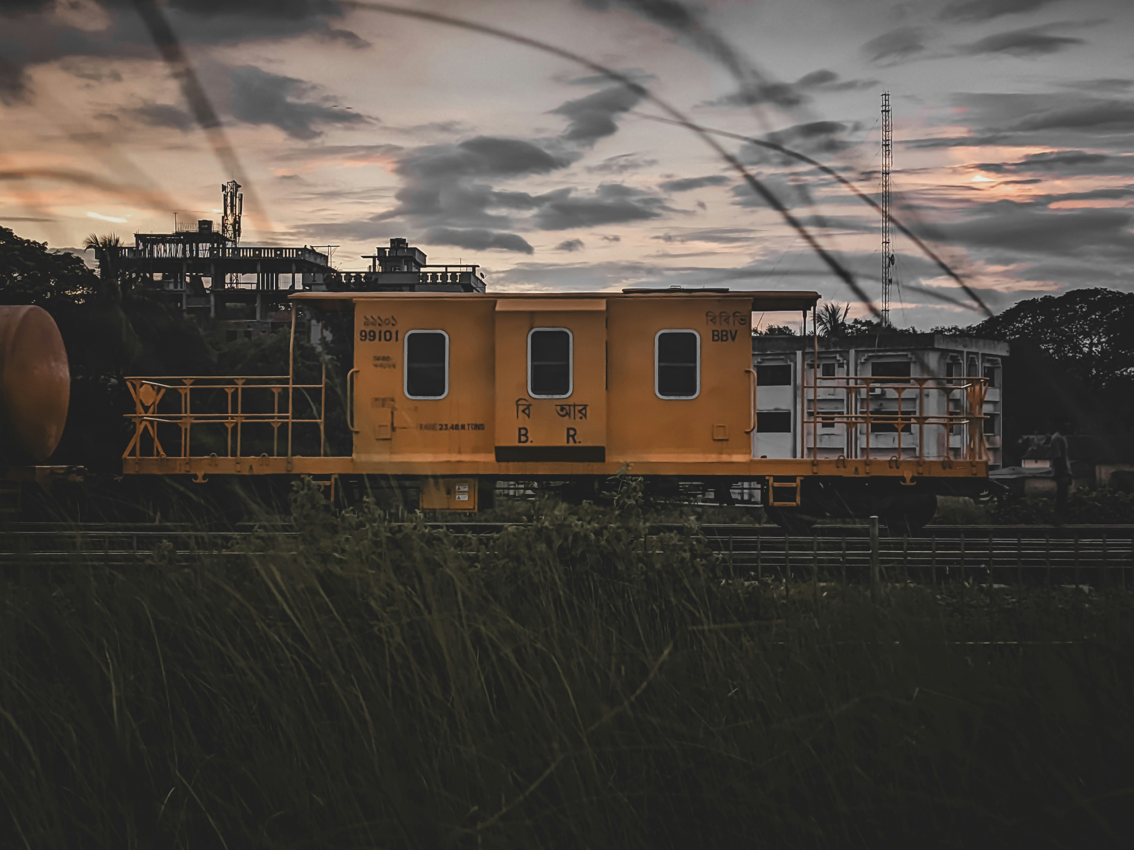 Yellow caboose on forgotten tracks at dusk