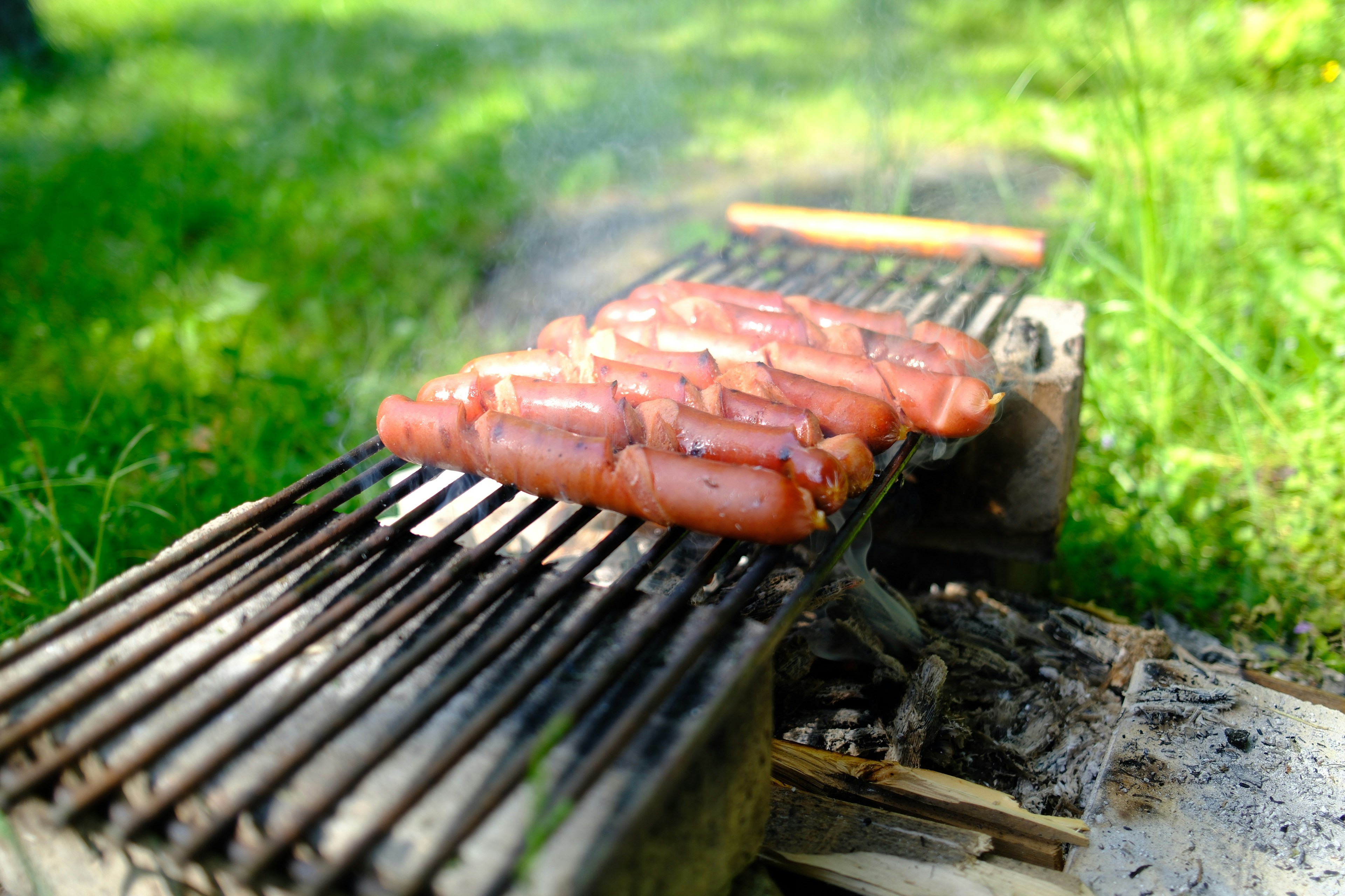 Sizzling Outdoor Skewers: Juicy Sausages Grilling Over Charred Wood