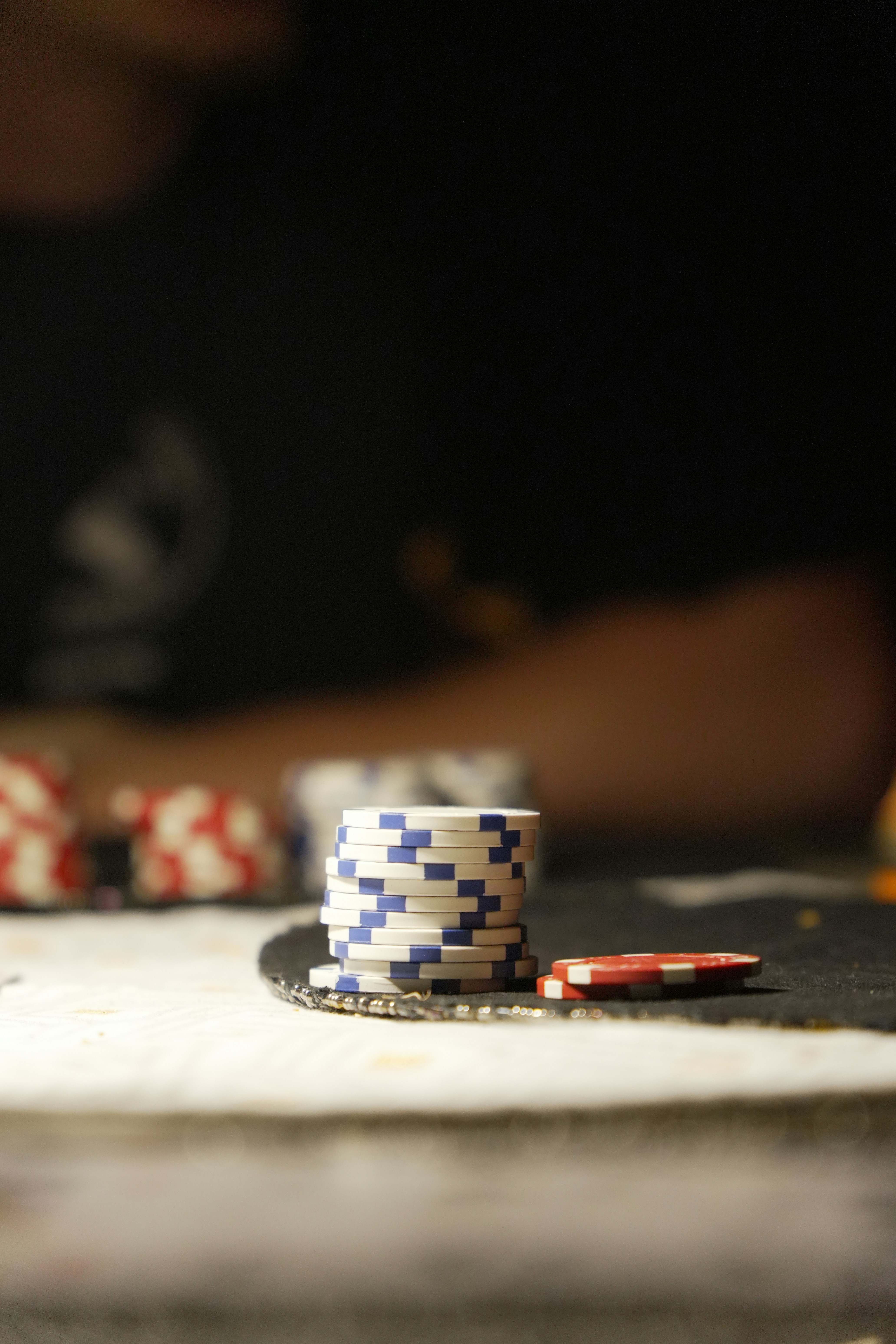 Stack of blue-and-white poker chips in focus on a casino table
