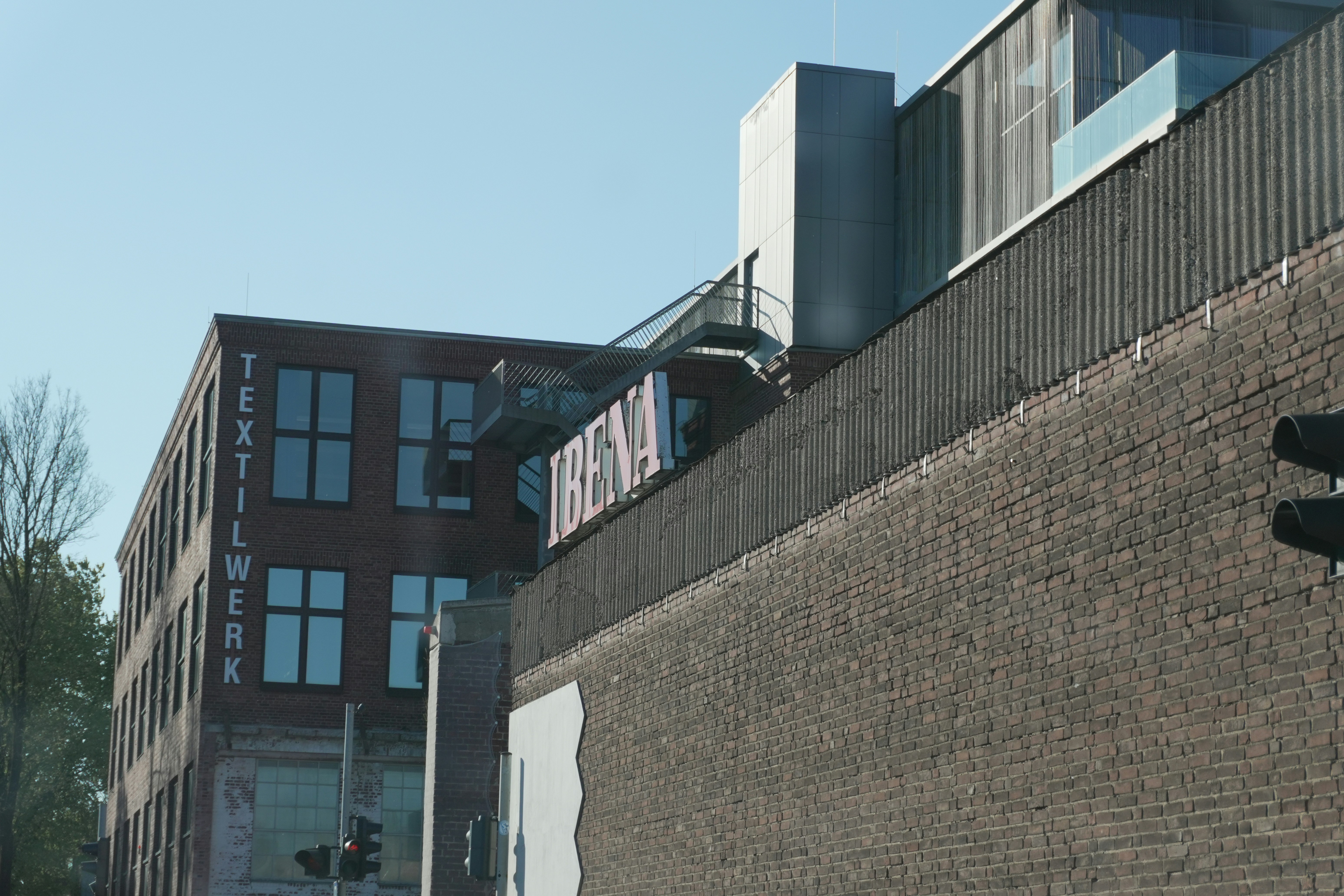 Historic "textilwerke" building under a clear blue sky.