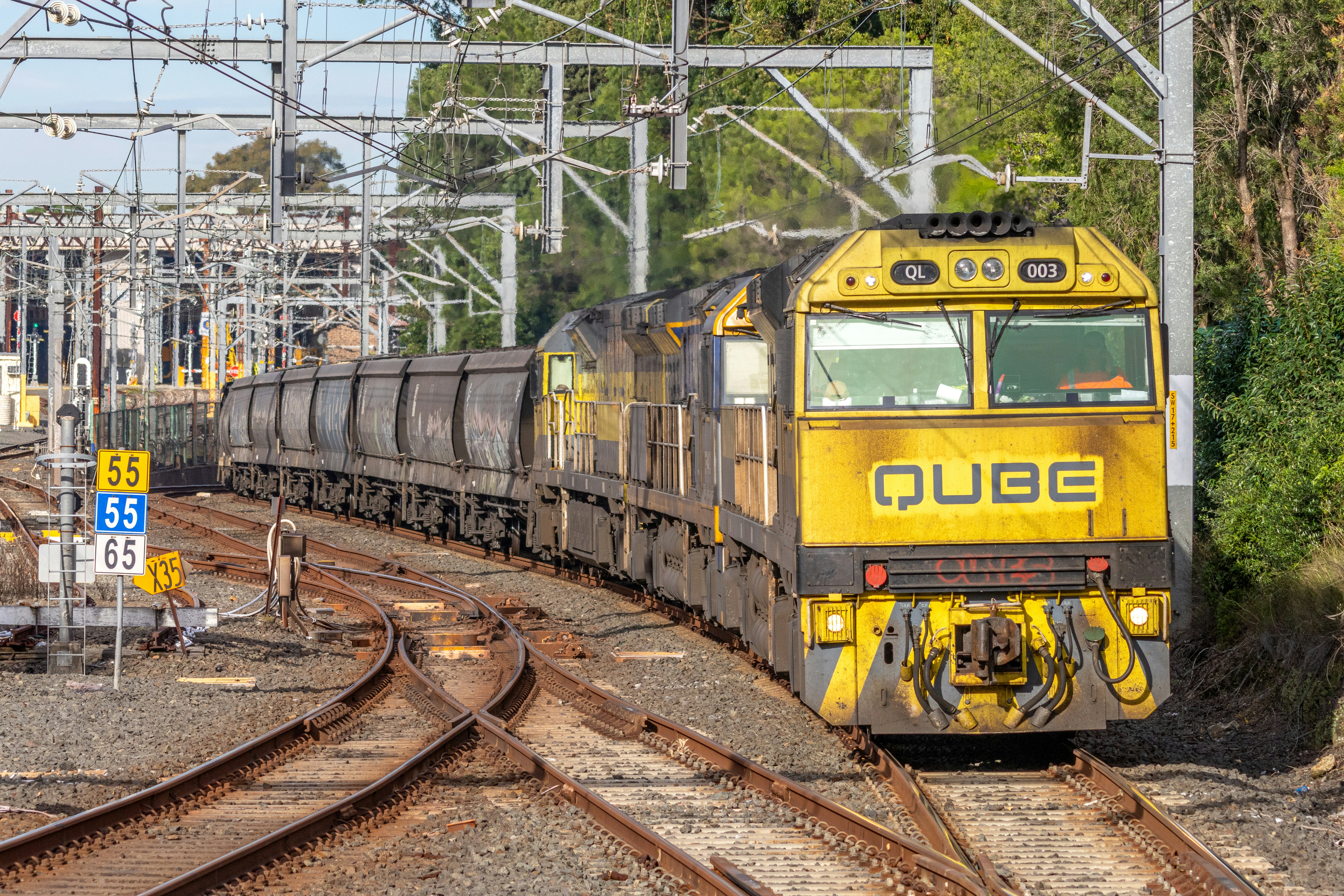 Yellow QUBE Diesel Locomotive Steaming Into Frame