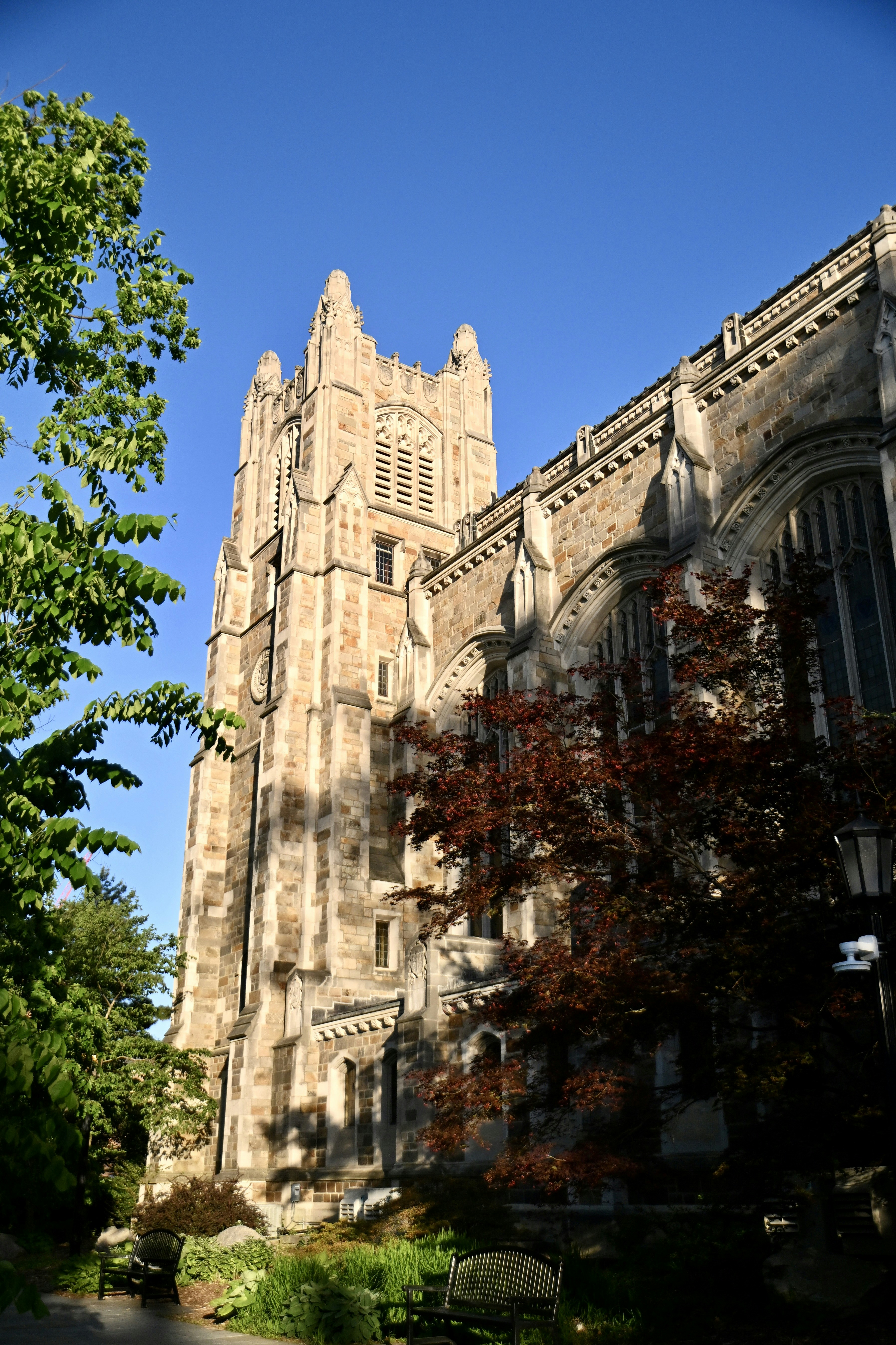 Historic stone building and tower against a clear blue sky.