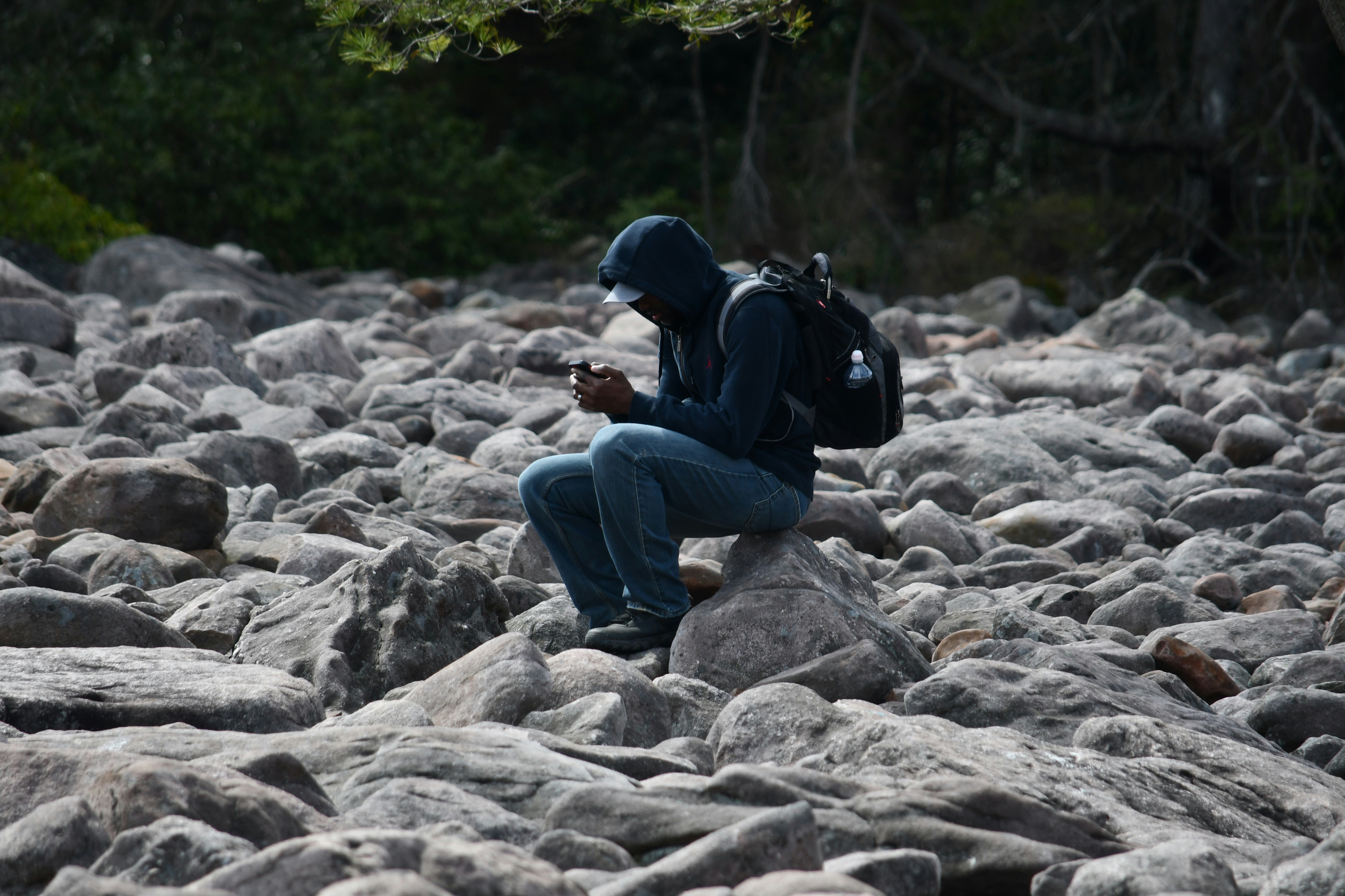 Hushed Focus: A Lone Hiker on Weathered Stones