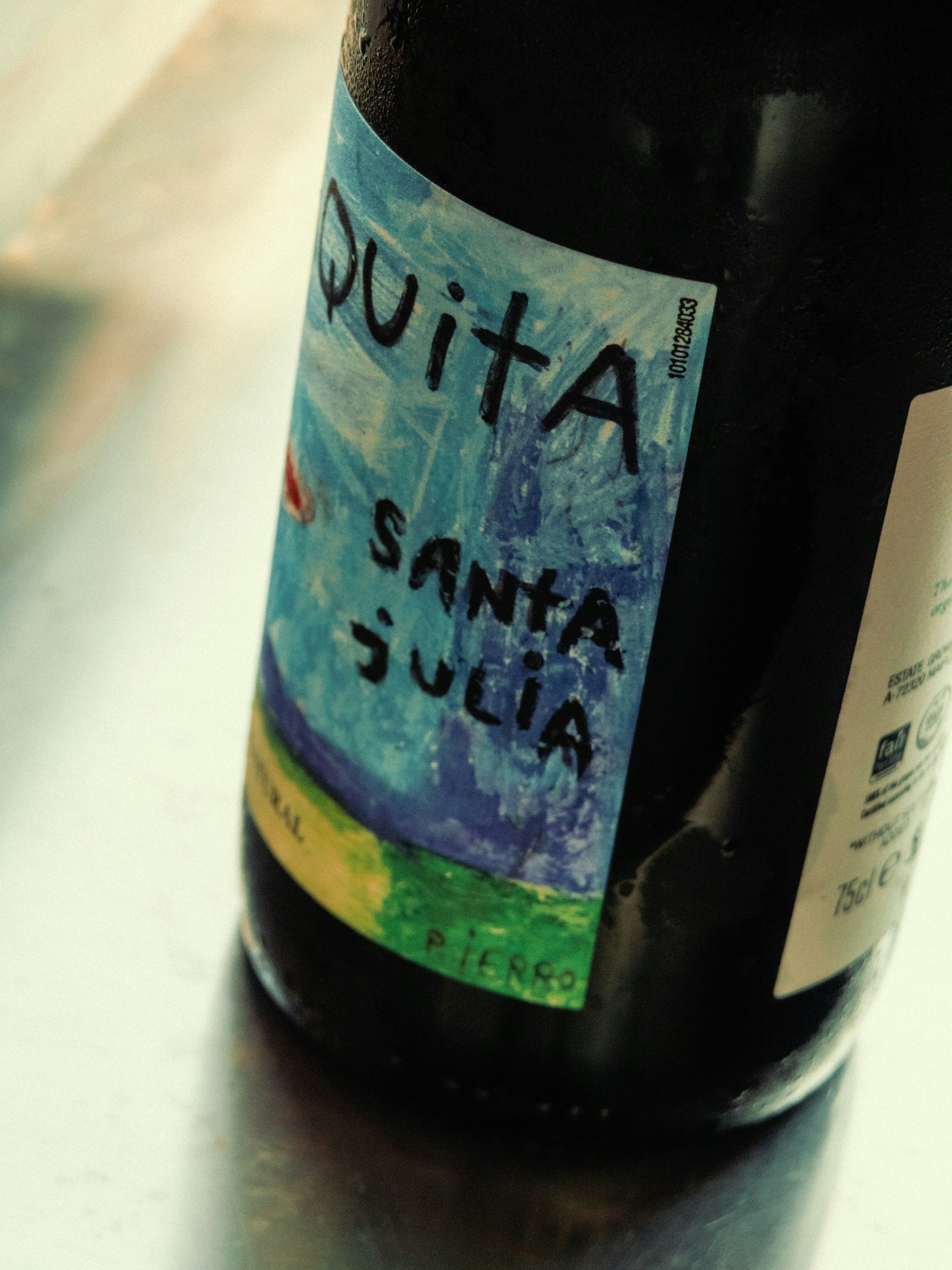 Blue-label bottle leaned into the frame on a reflective surface