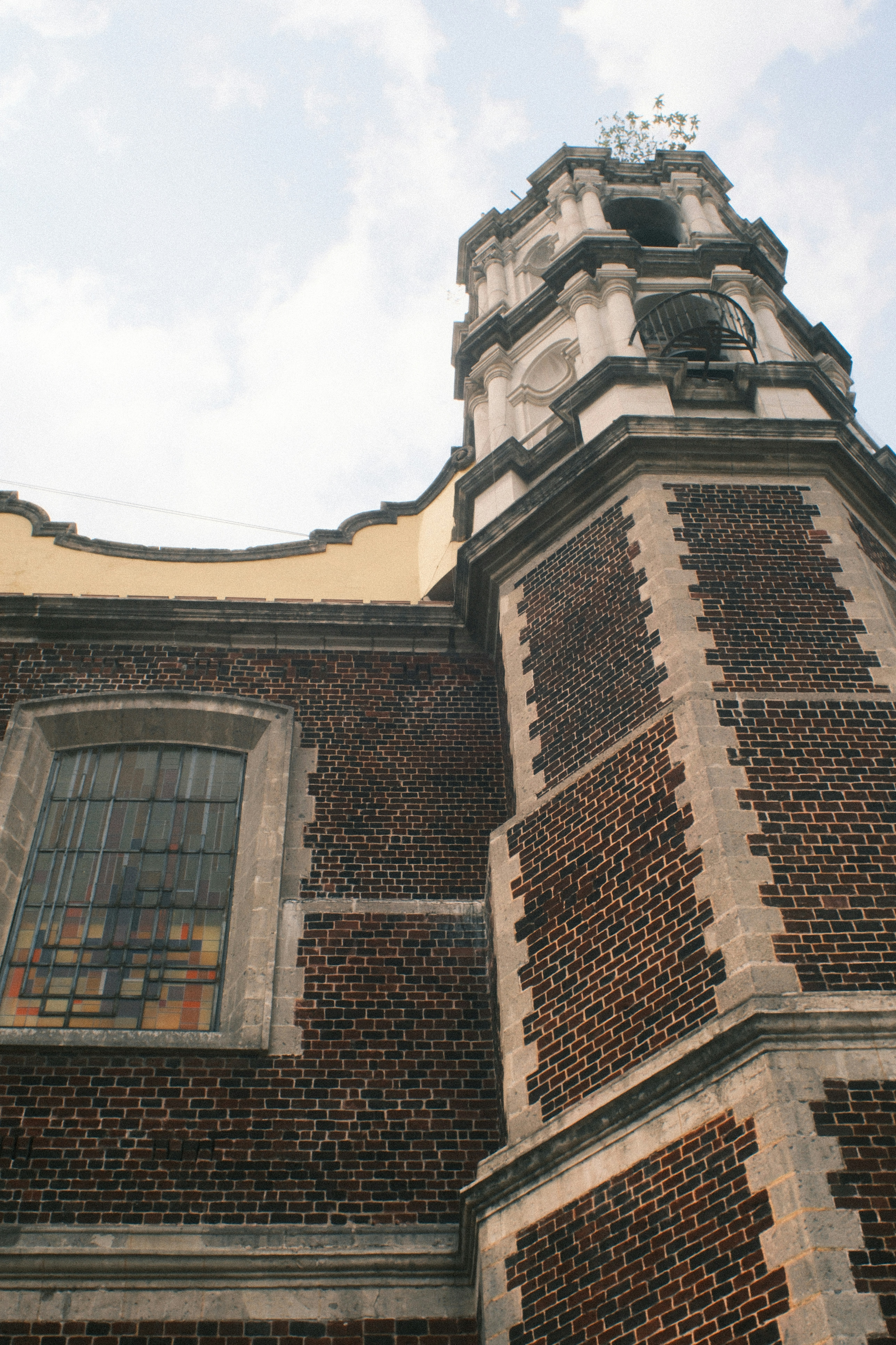 Brick Bell Tower Reaches Toward a Clouded Sky