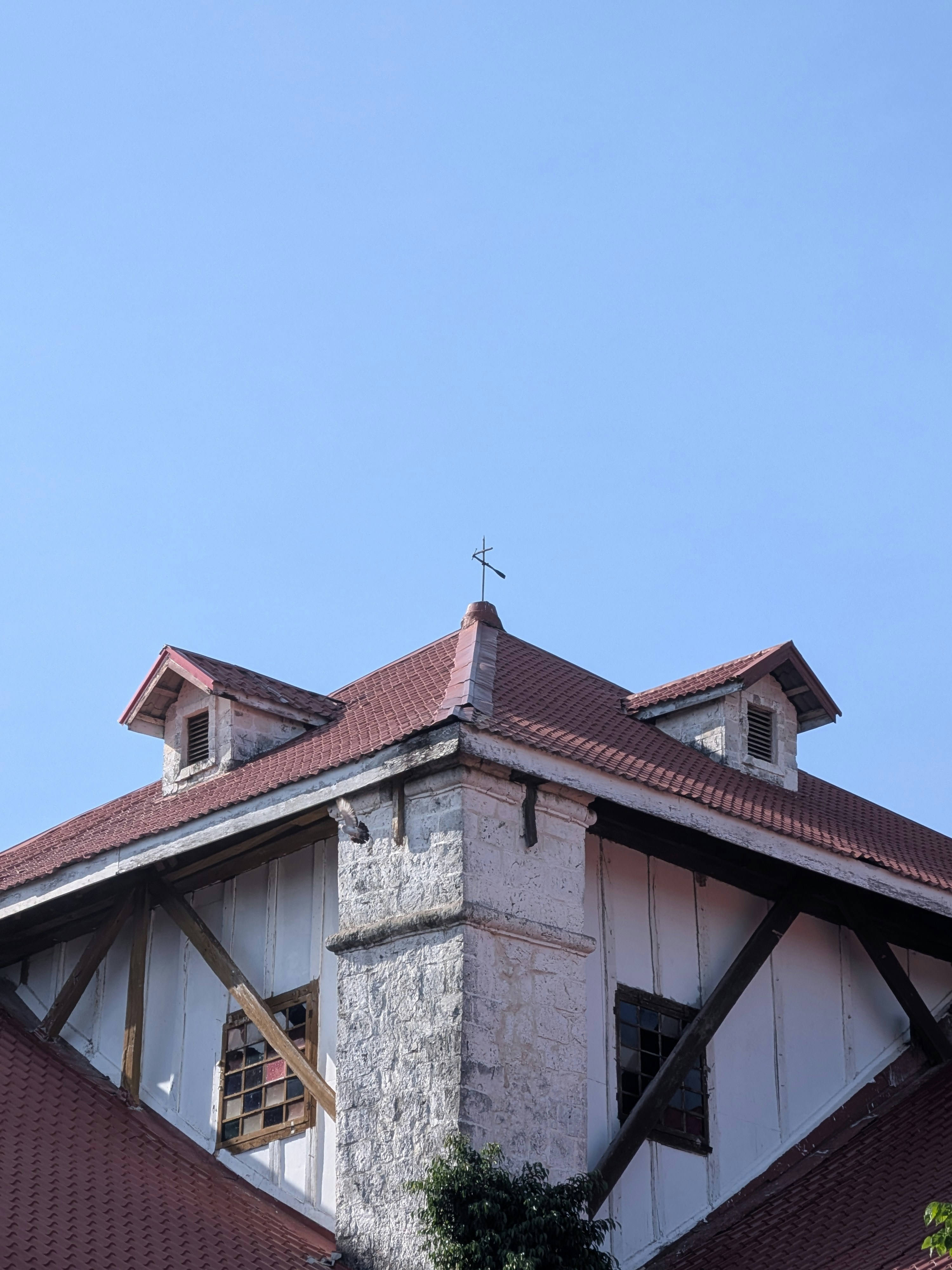 Historic building with red tiled roof and clear blue sky.