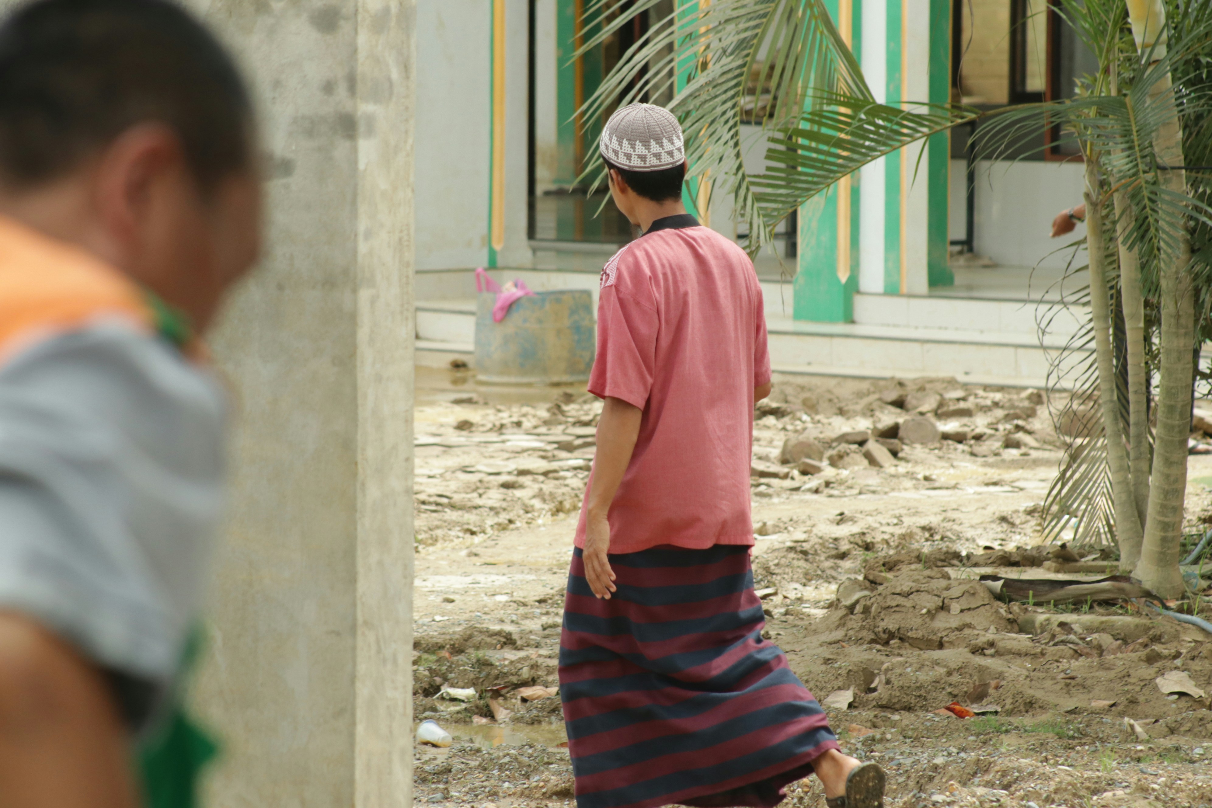 Striding figure in a sunlit, developing-site backdrop