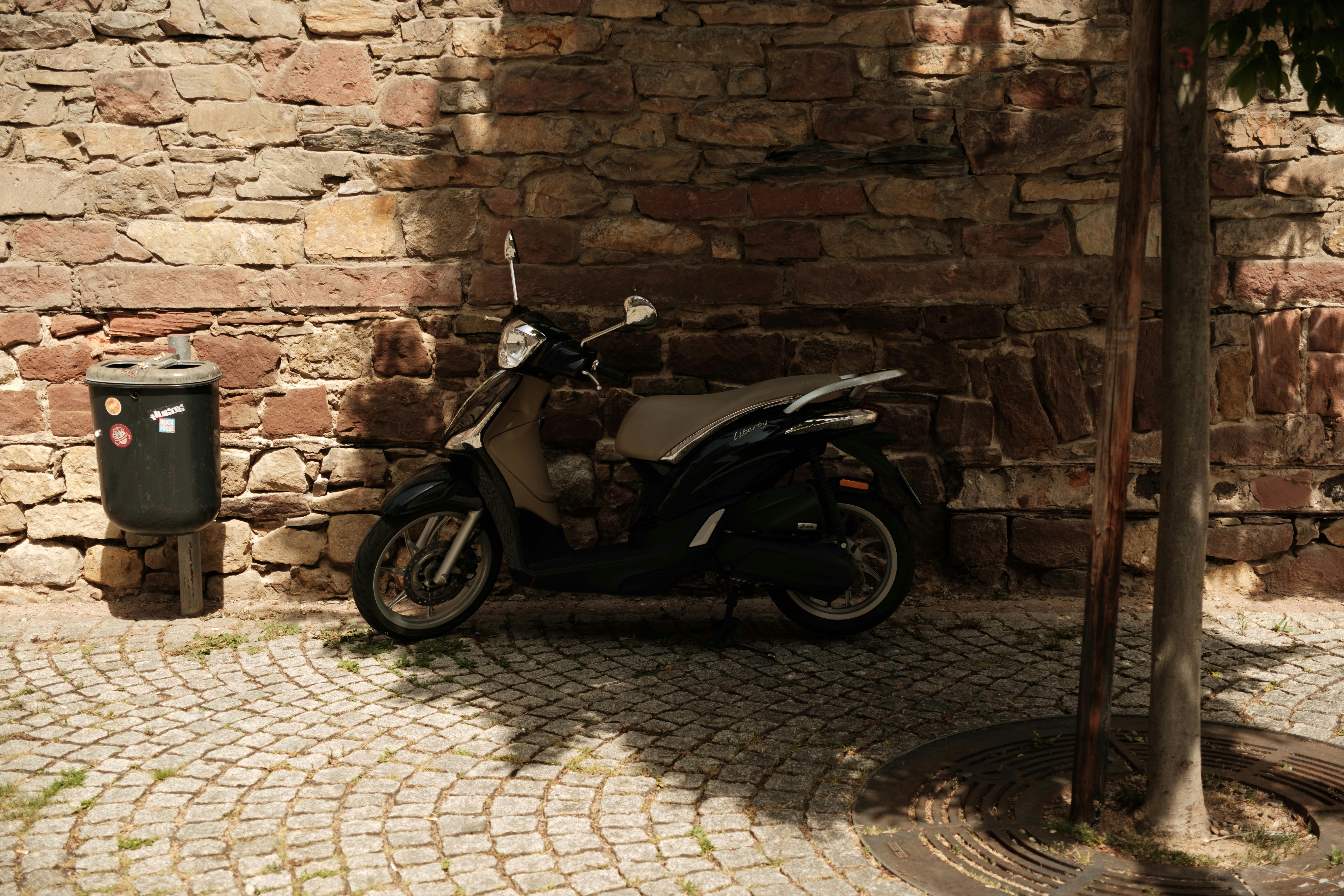 Sunlit Scooter Resting Against Ancient Stone