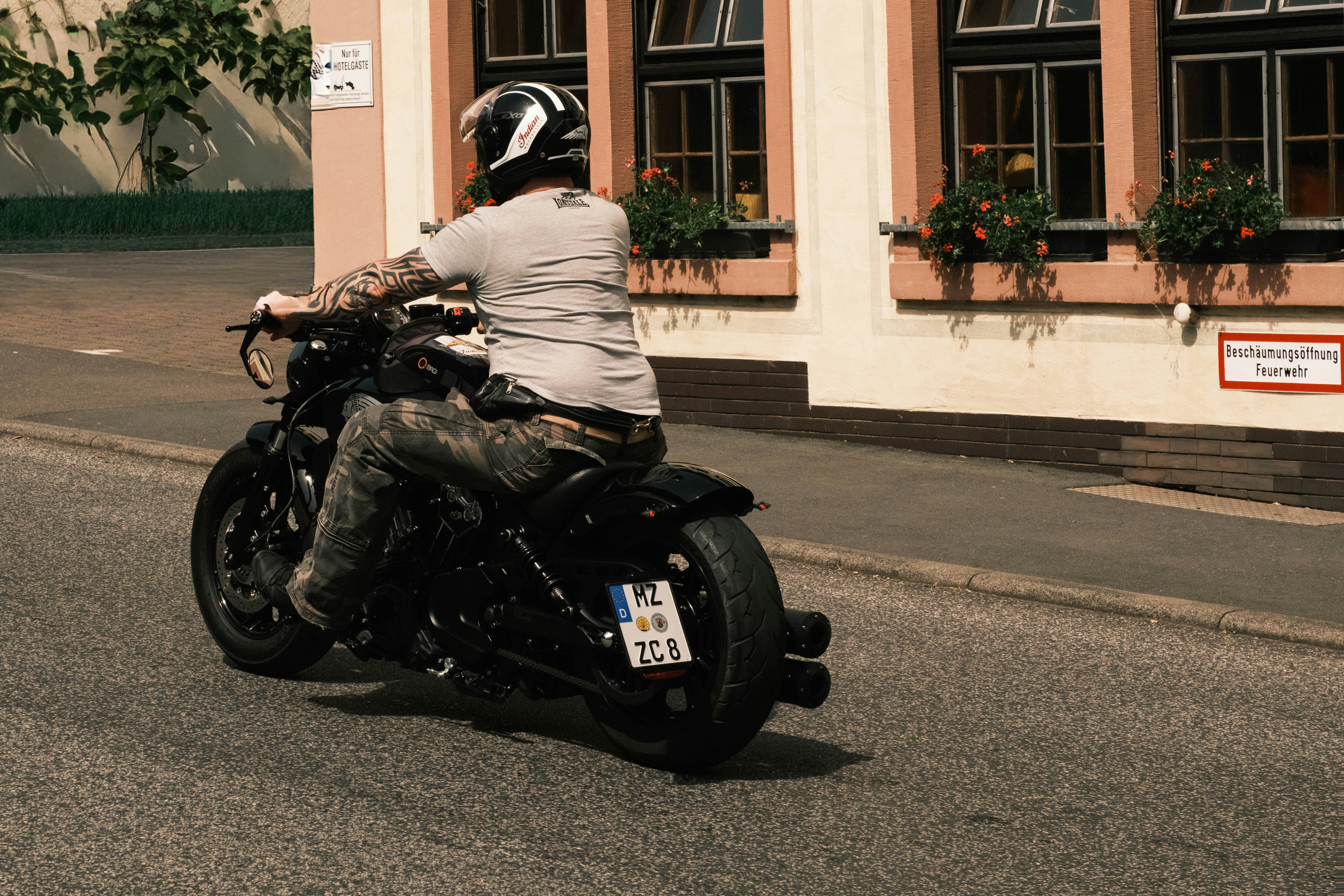 A person rides a black motorcycle on a paved street.