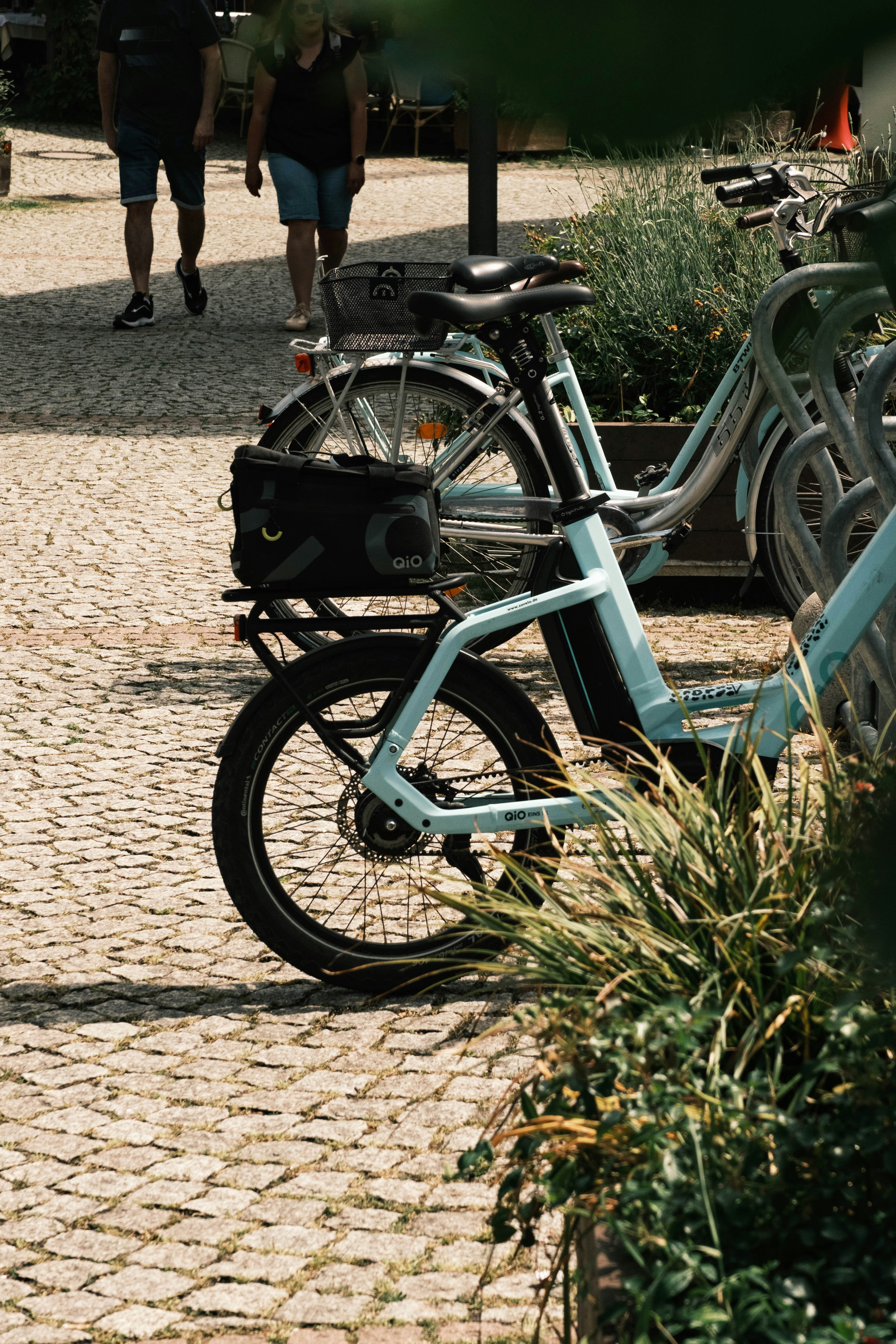 Electric Rides and Quiet Footpaths: A Row of Bicycles Gracing a Cobblestoned Lane