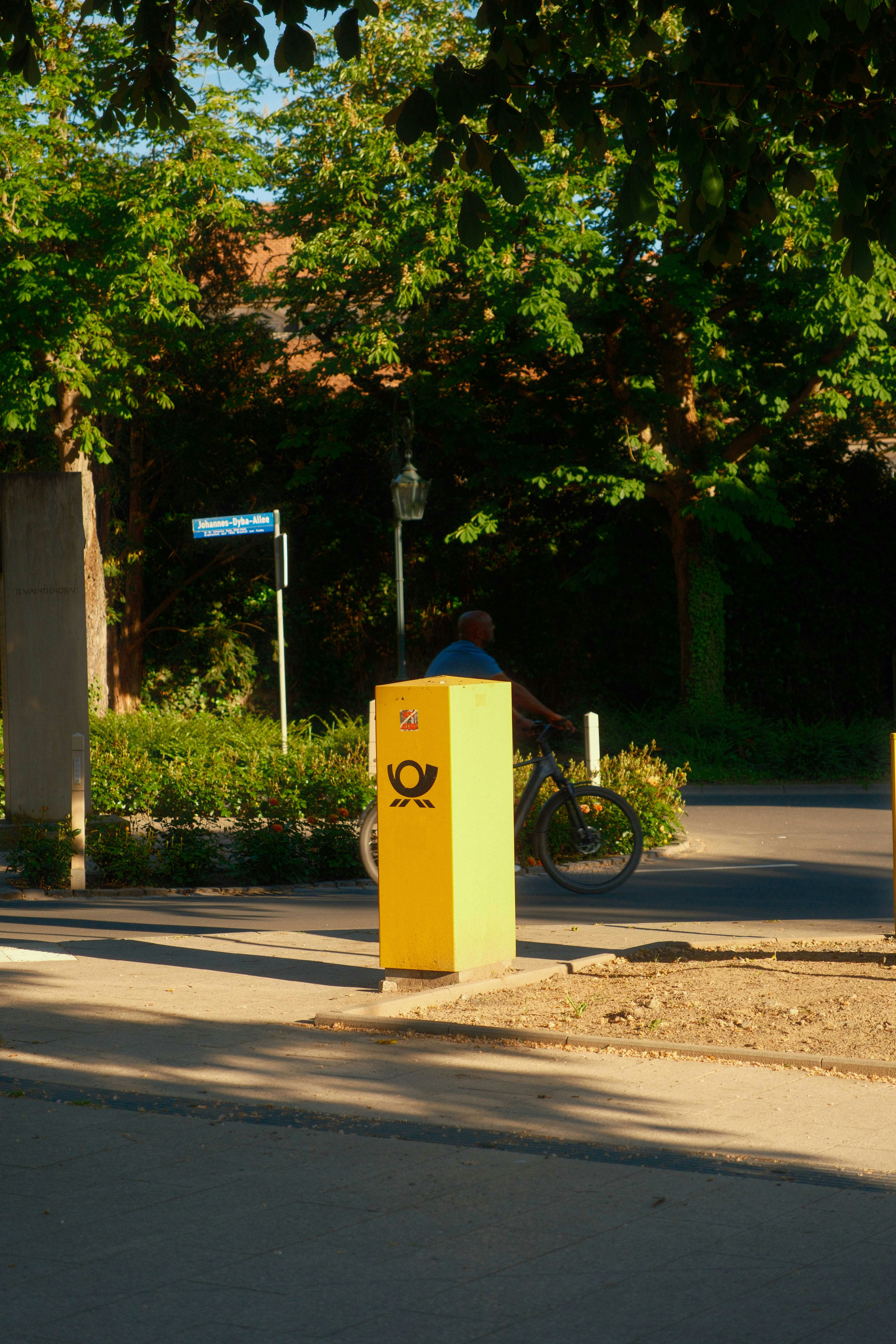 Yellow Street Post guard: a cyclist pauses near a bright marker