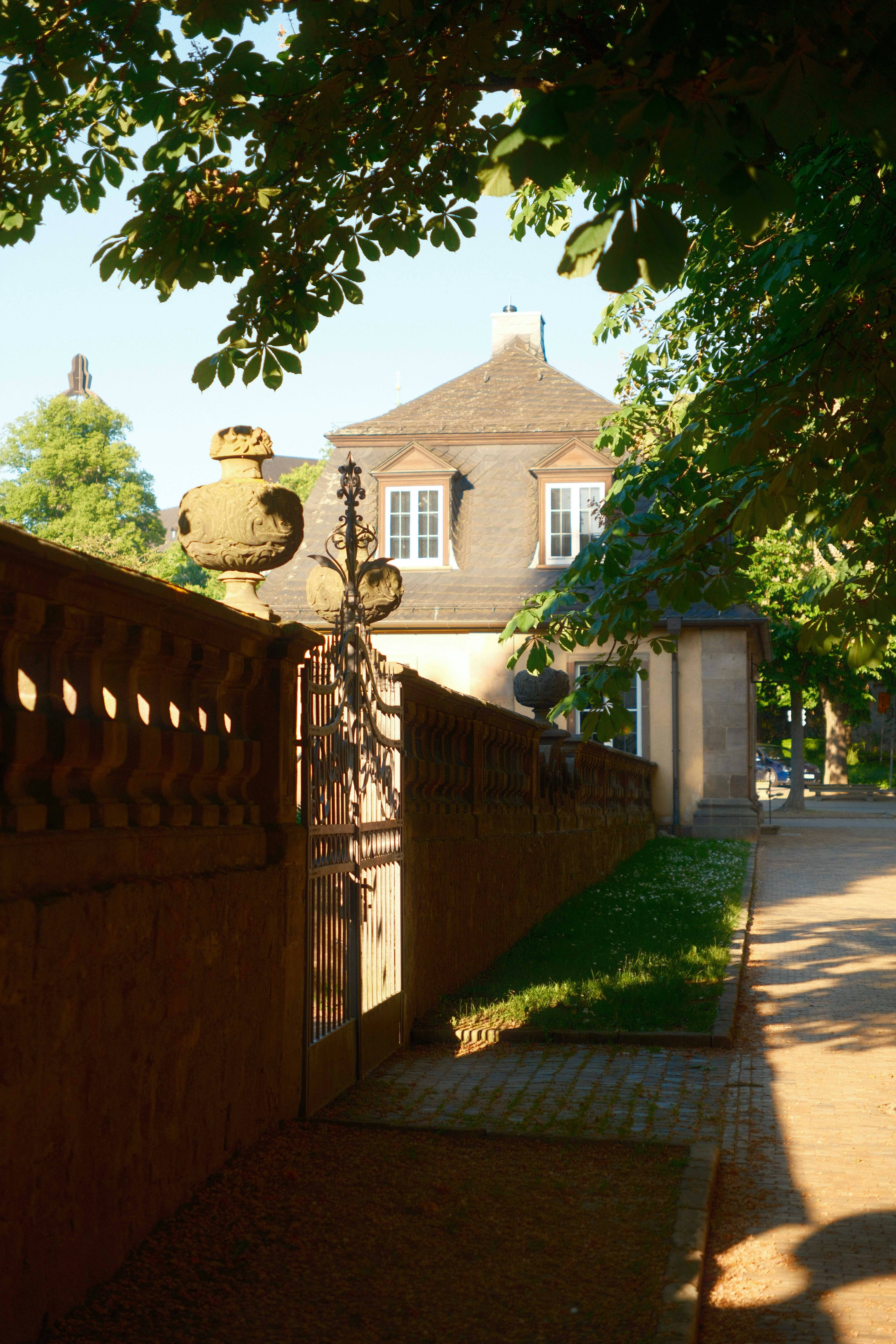 Sunlit Mansion Gate: A Quiet Path Framed by Shade