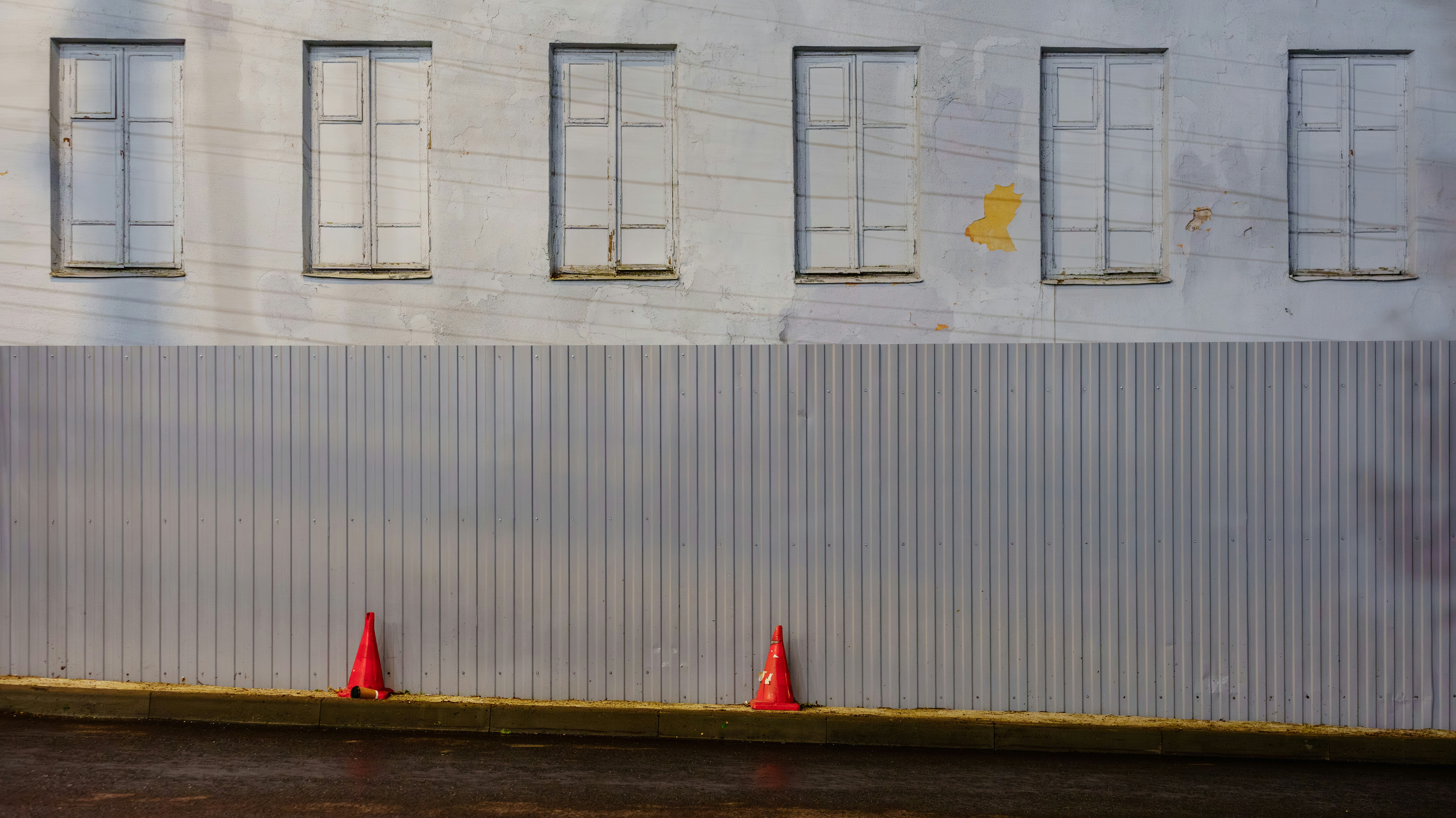 Concrete Curtain: Red Cones Mark the Street’s Quiet Boundary