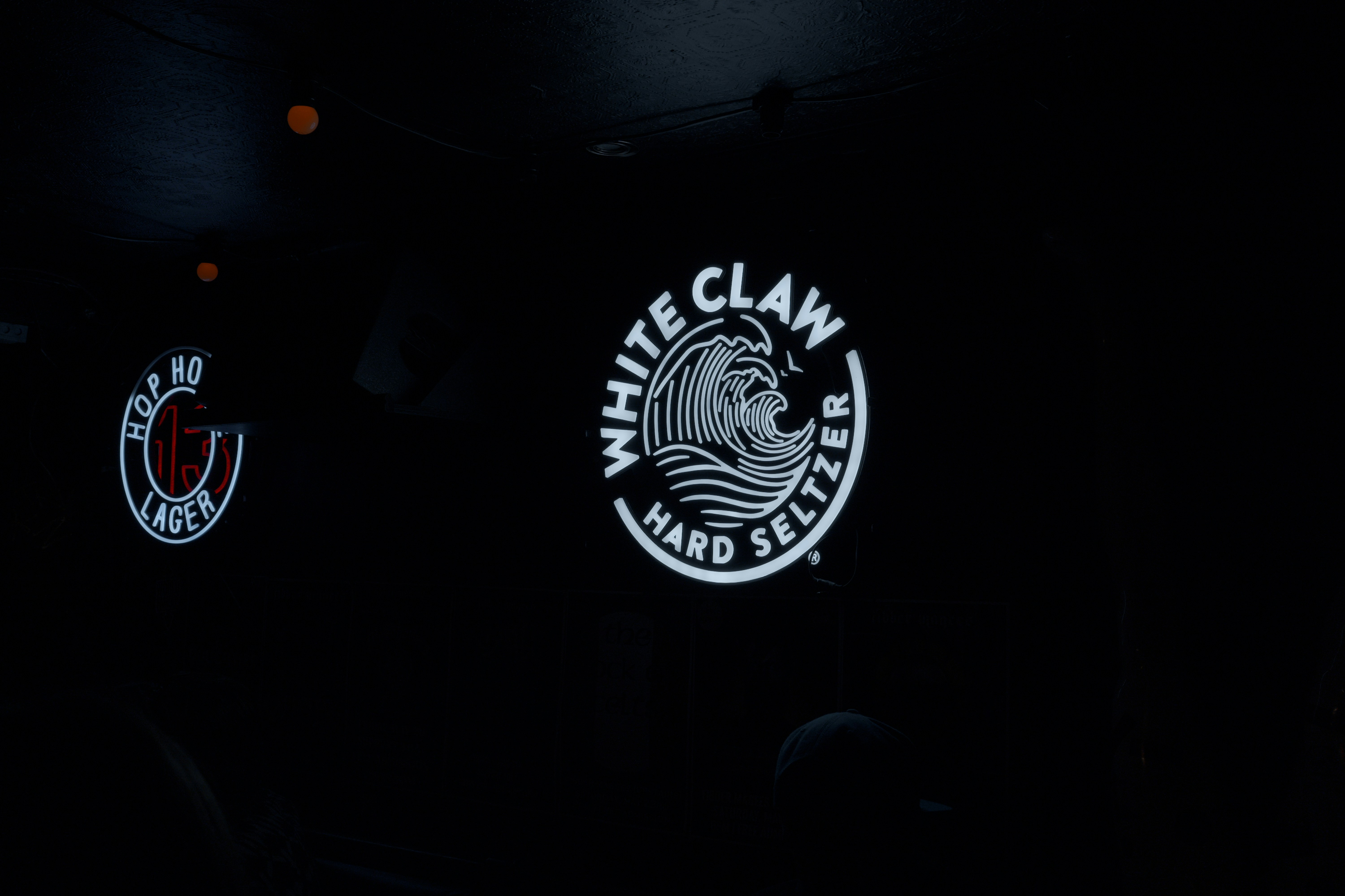 Neon Seal: White Claw Sign in a Dim Bar