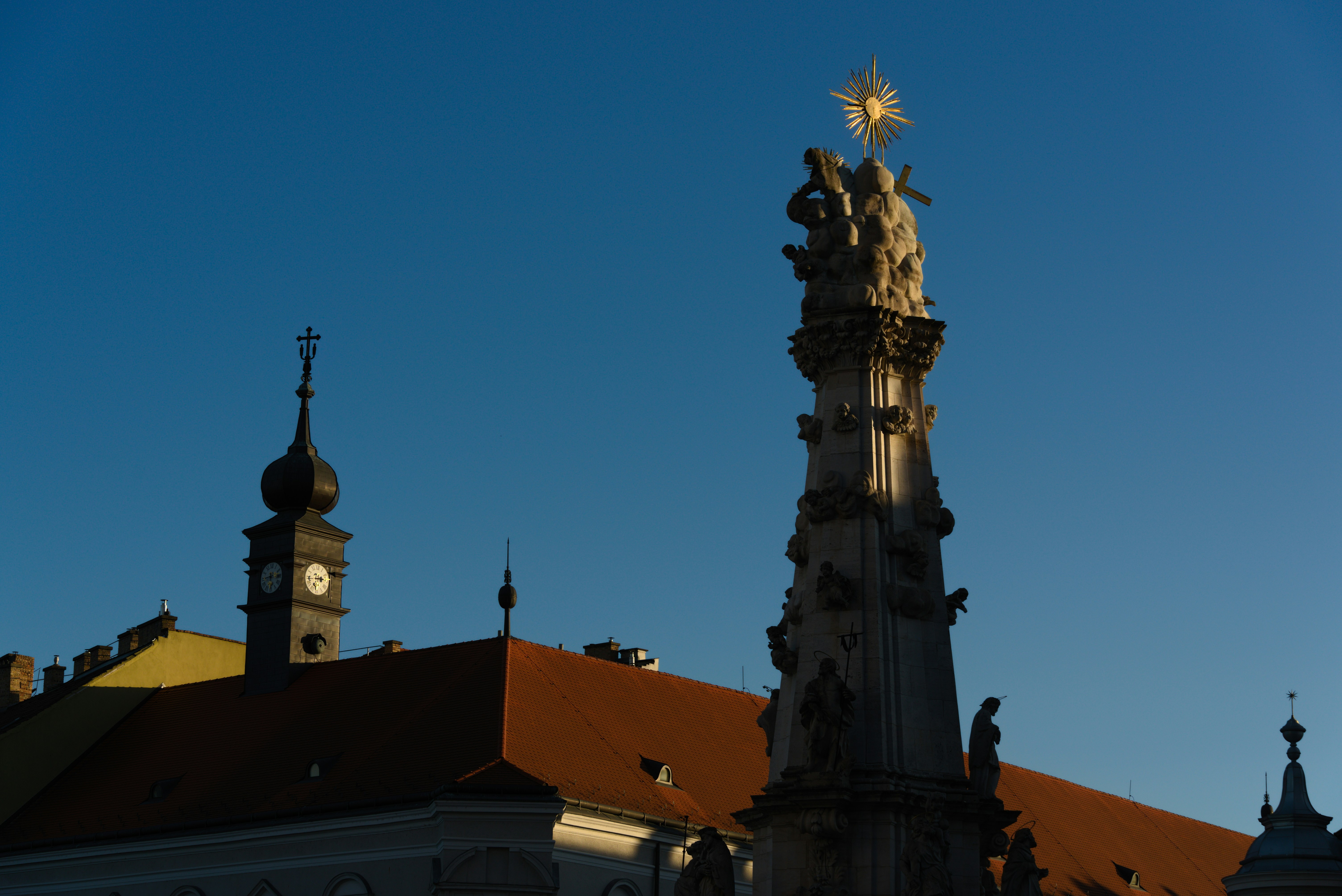 Stone Carved Obelisk Framing a Rooftop Majesty at Dusk