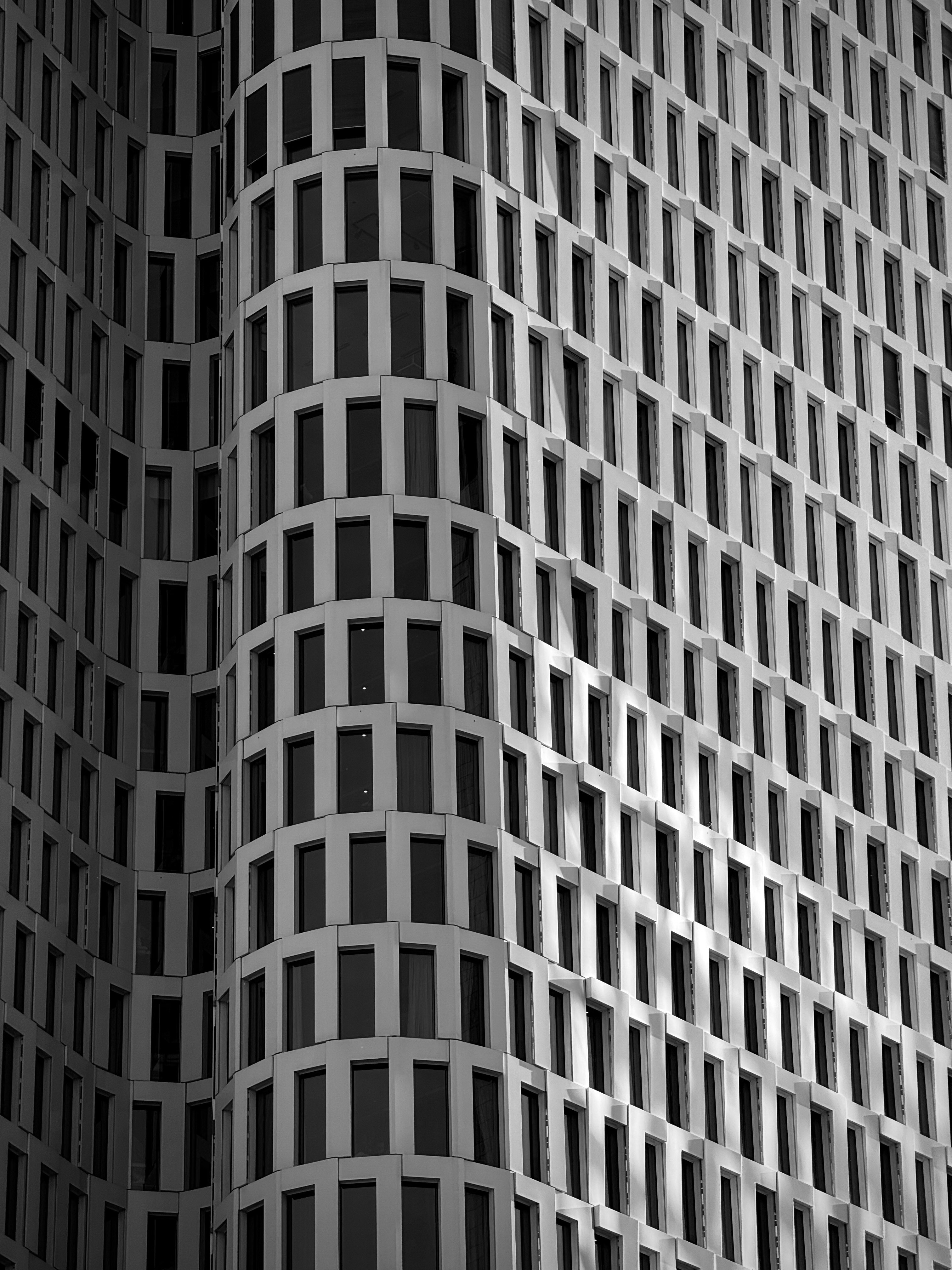 Modern building facade with many windows and a curved corner.