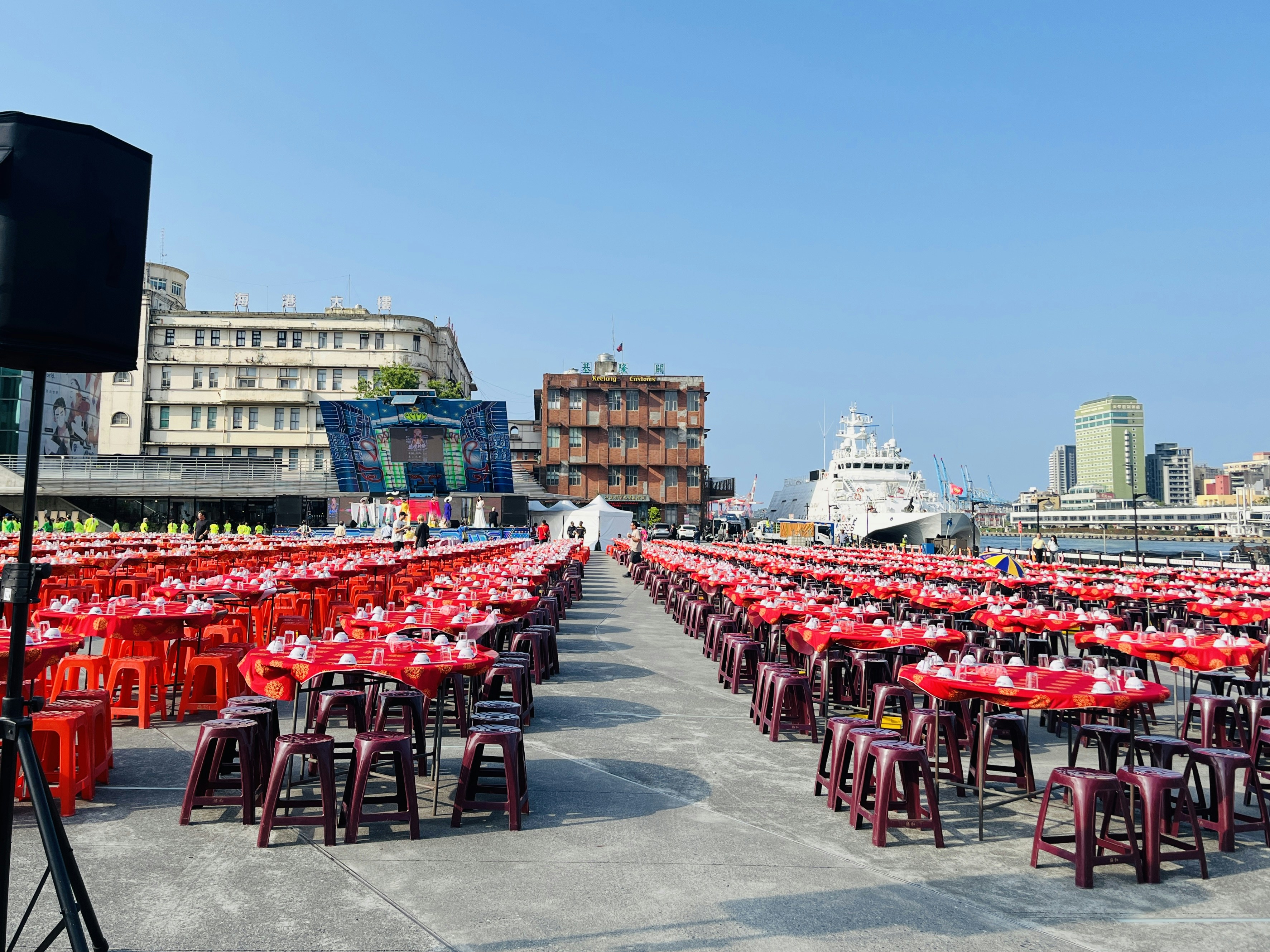 Long rows of red tables and stools set outdoors.
