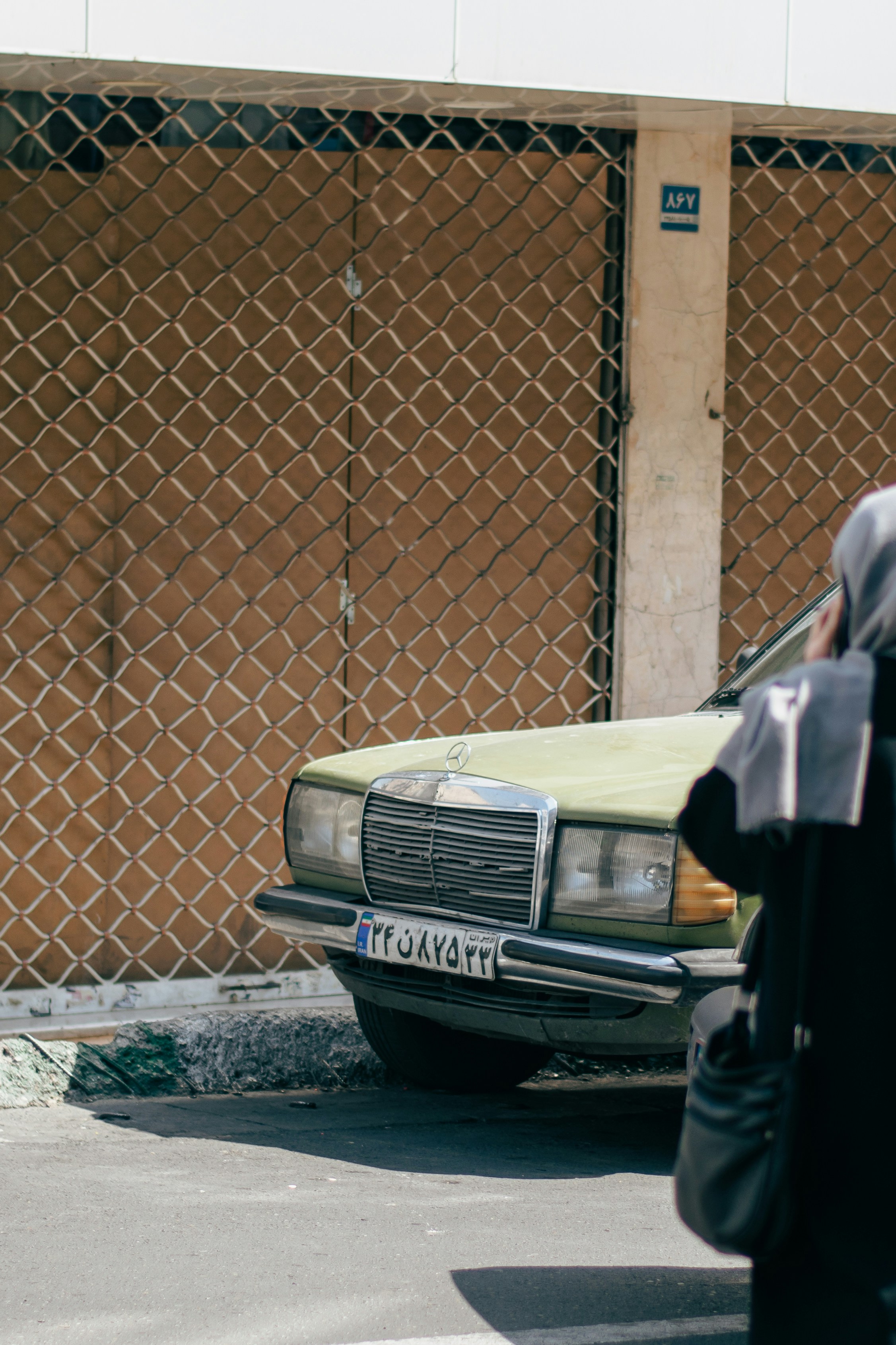 Waiting by the Fence: A Vintage Mercedes Under Dappled Light