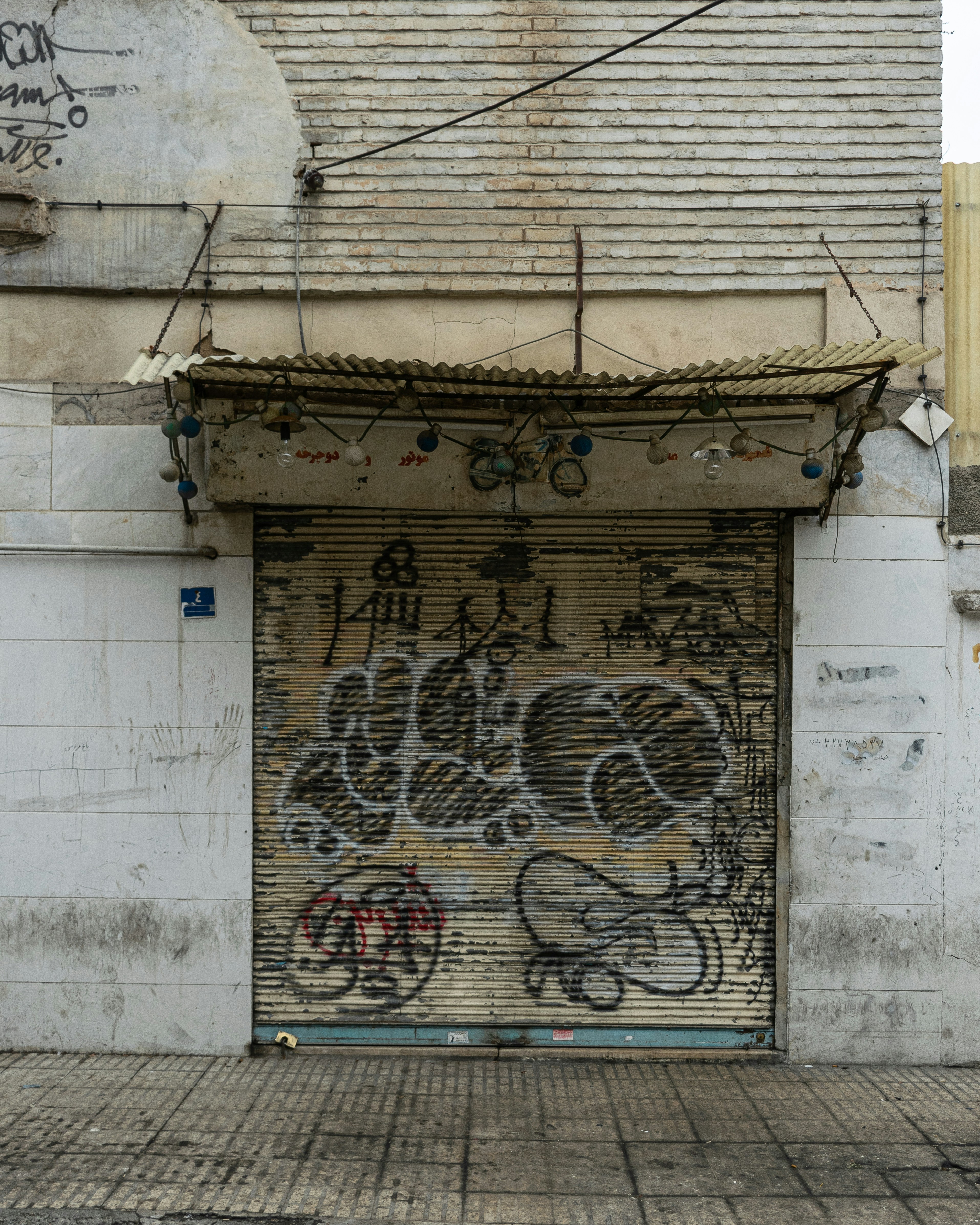 Closed Graffiti Shrine: A Shuttered Alleyway Wall with Graffiti Reverie
