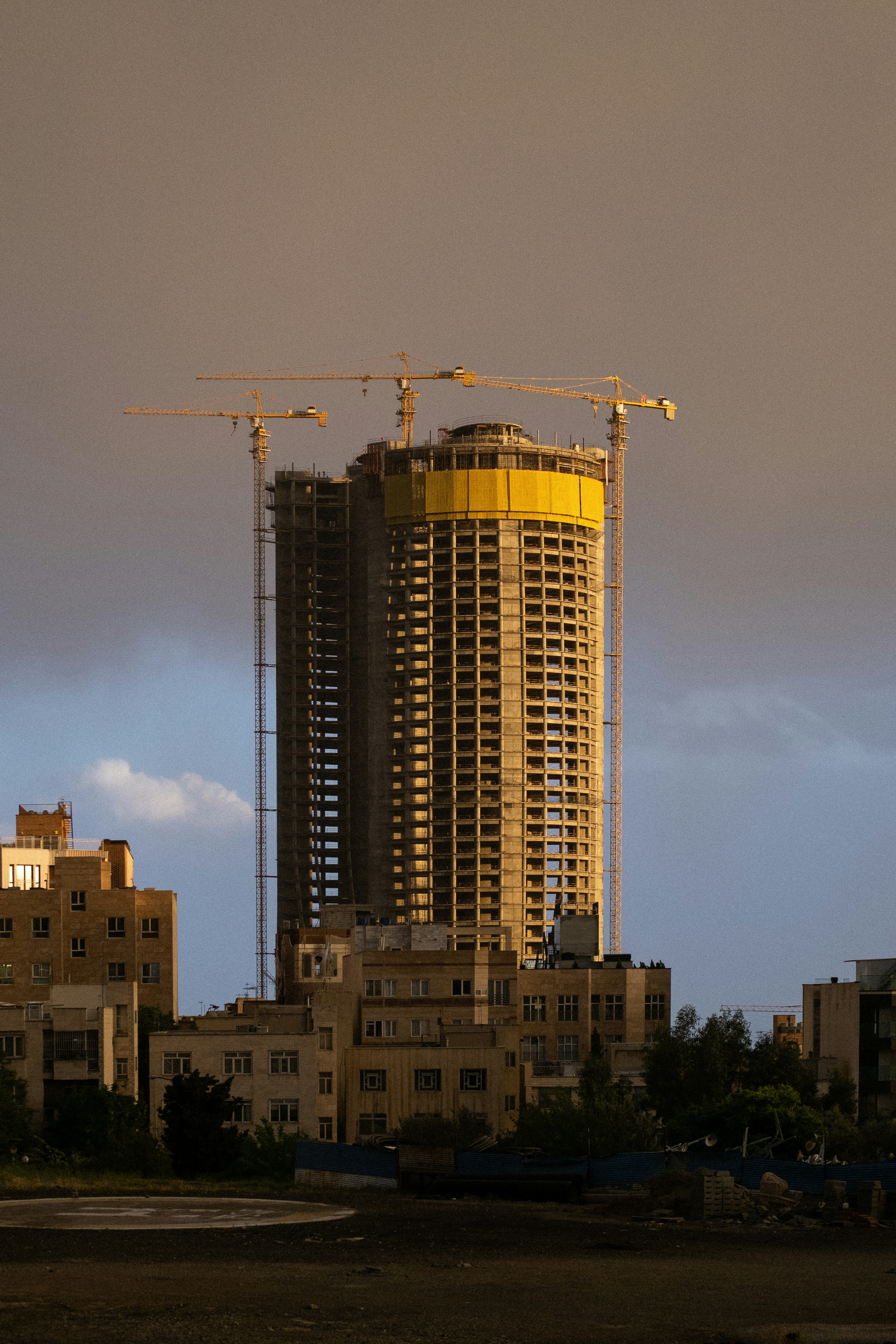 Towering Progress: Crane-Crowned High-Rise Rises Over a Quiet City