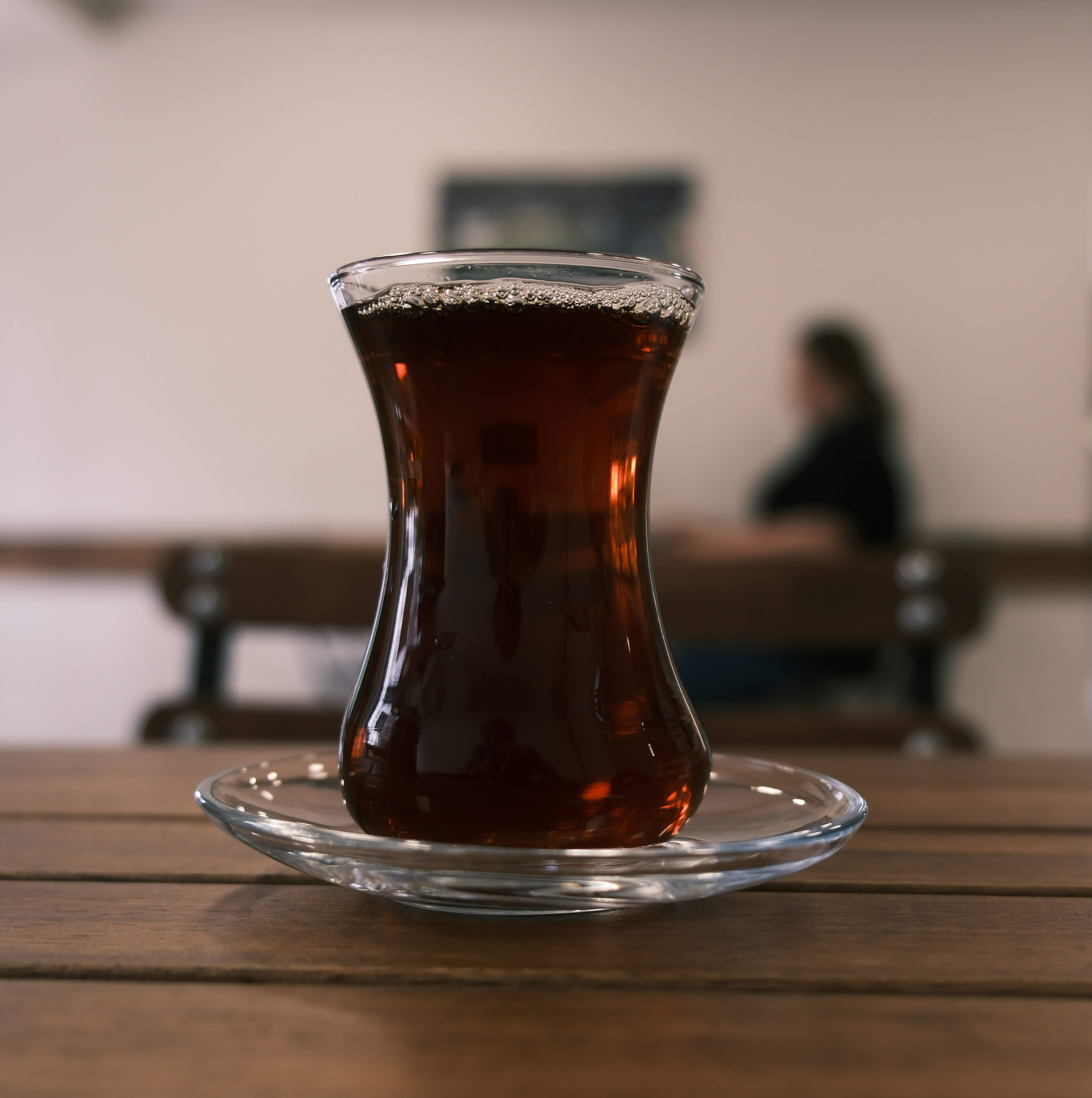 Tea Glass on a Wooden Table with Blurred Café Background