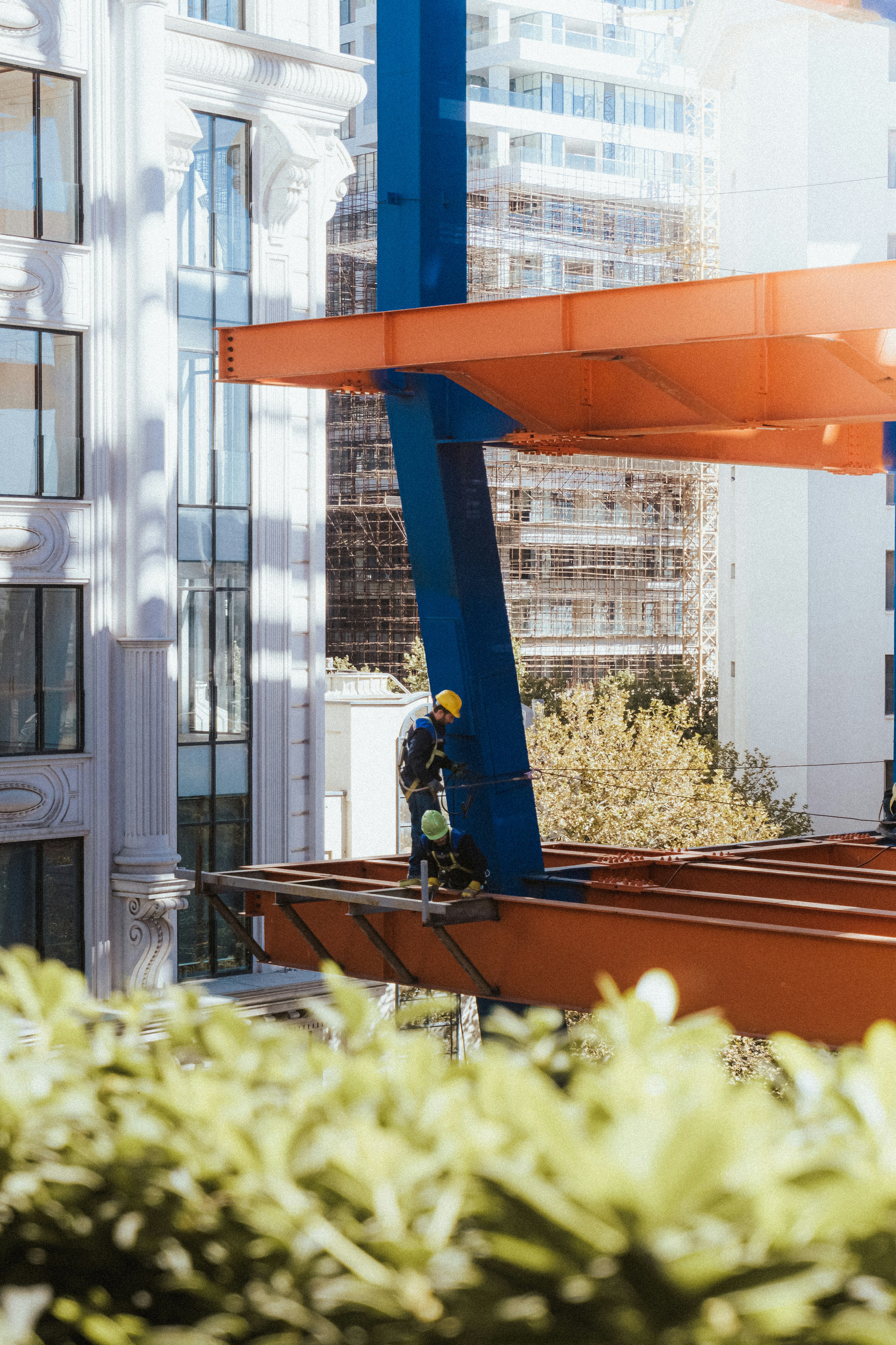 Steel Skyline: Construction Crew at the Edge of an Orange Arm